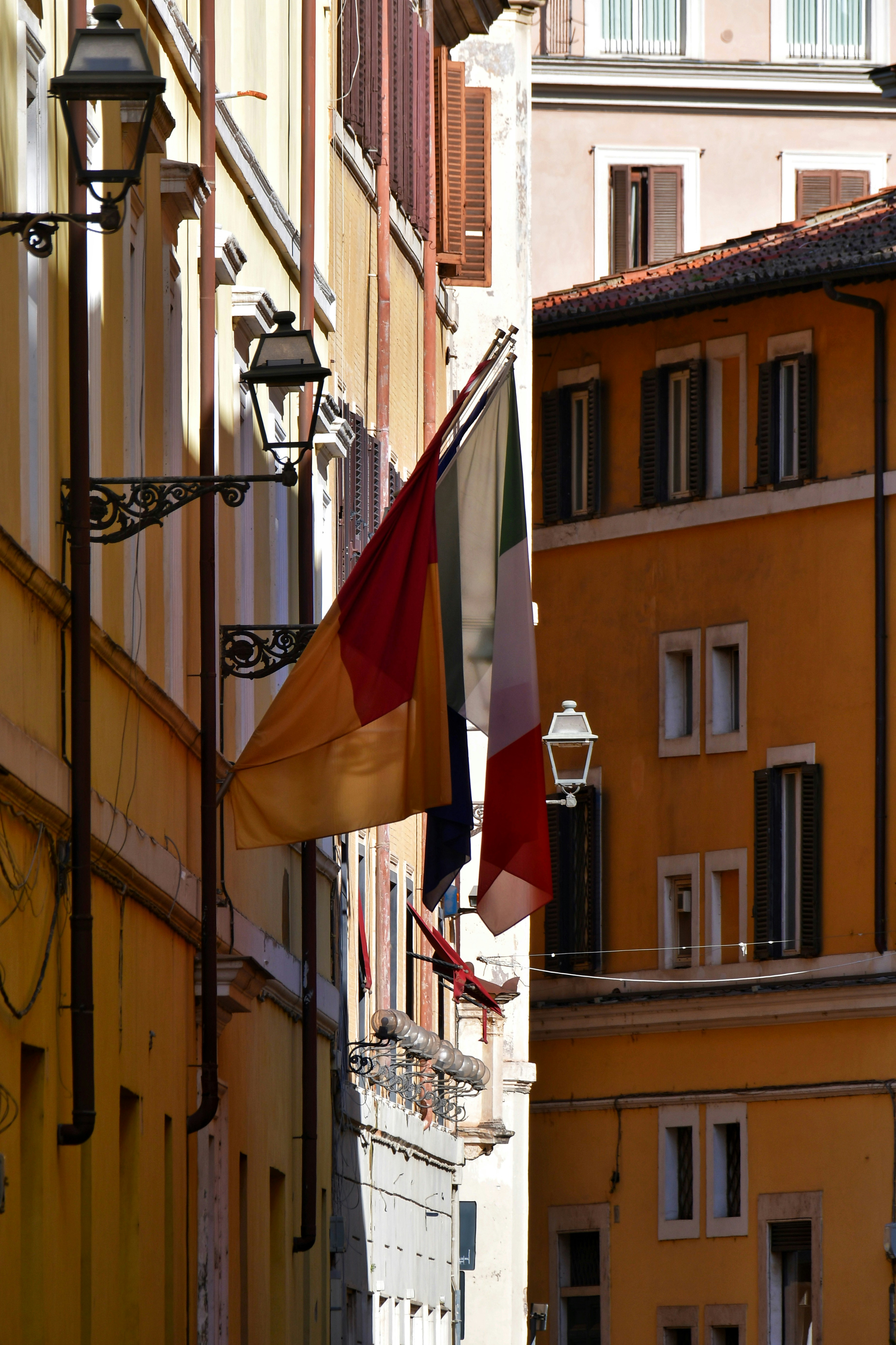 Sunlit Italian Alley Flags: Draped Color Along Narrow Facades