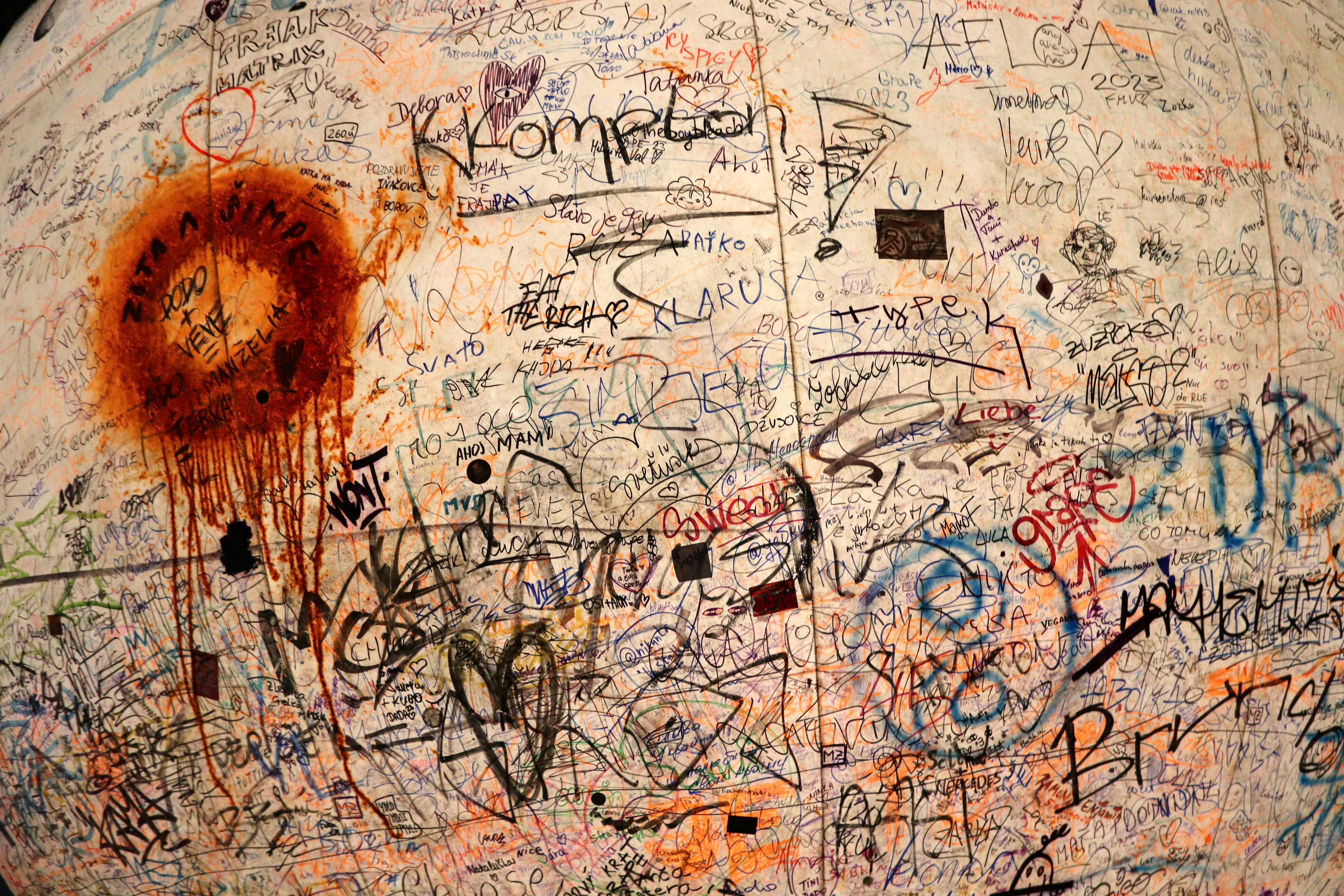 Orange Ring Anchors a Graffiti-Layered Wall