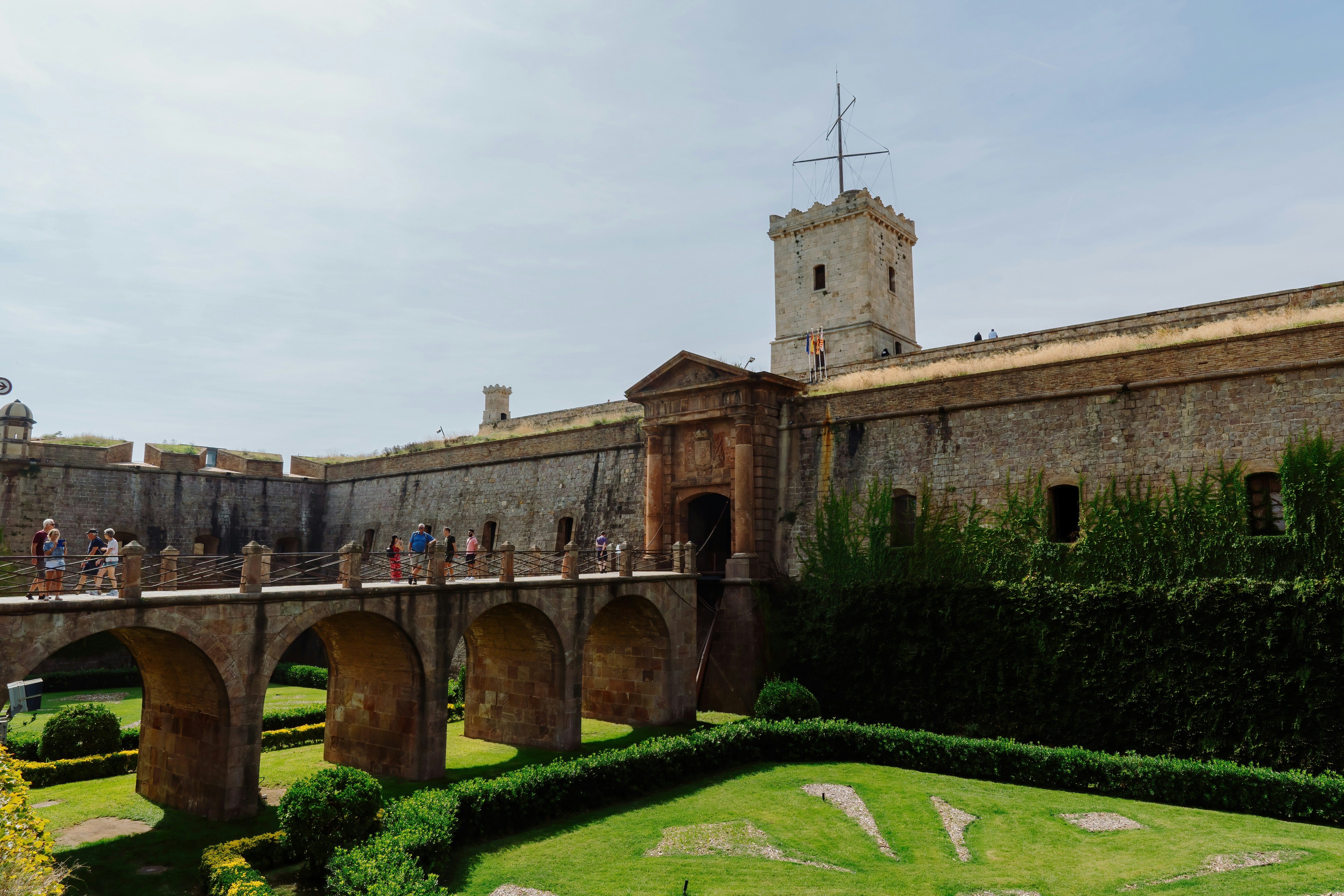 Un puente sobre un exuberante campo verde junto a un edificio alto foto ...