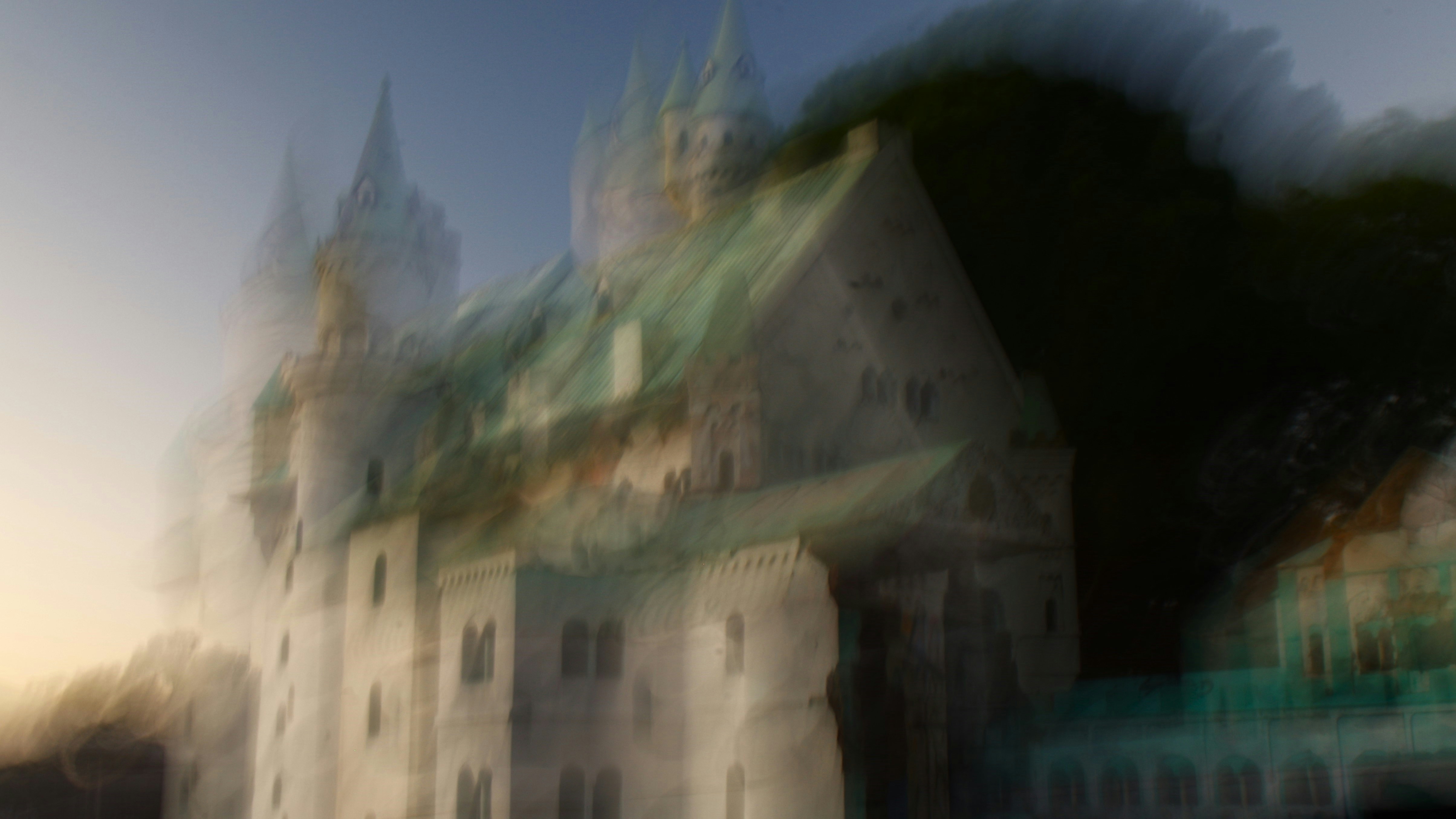 A blurred photograph of a castle-like fortress with motion blur from camera shake at dusk.