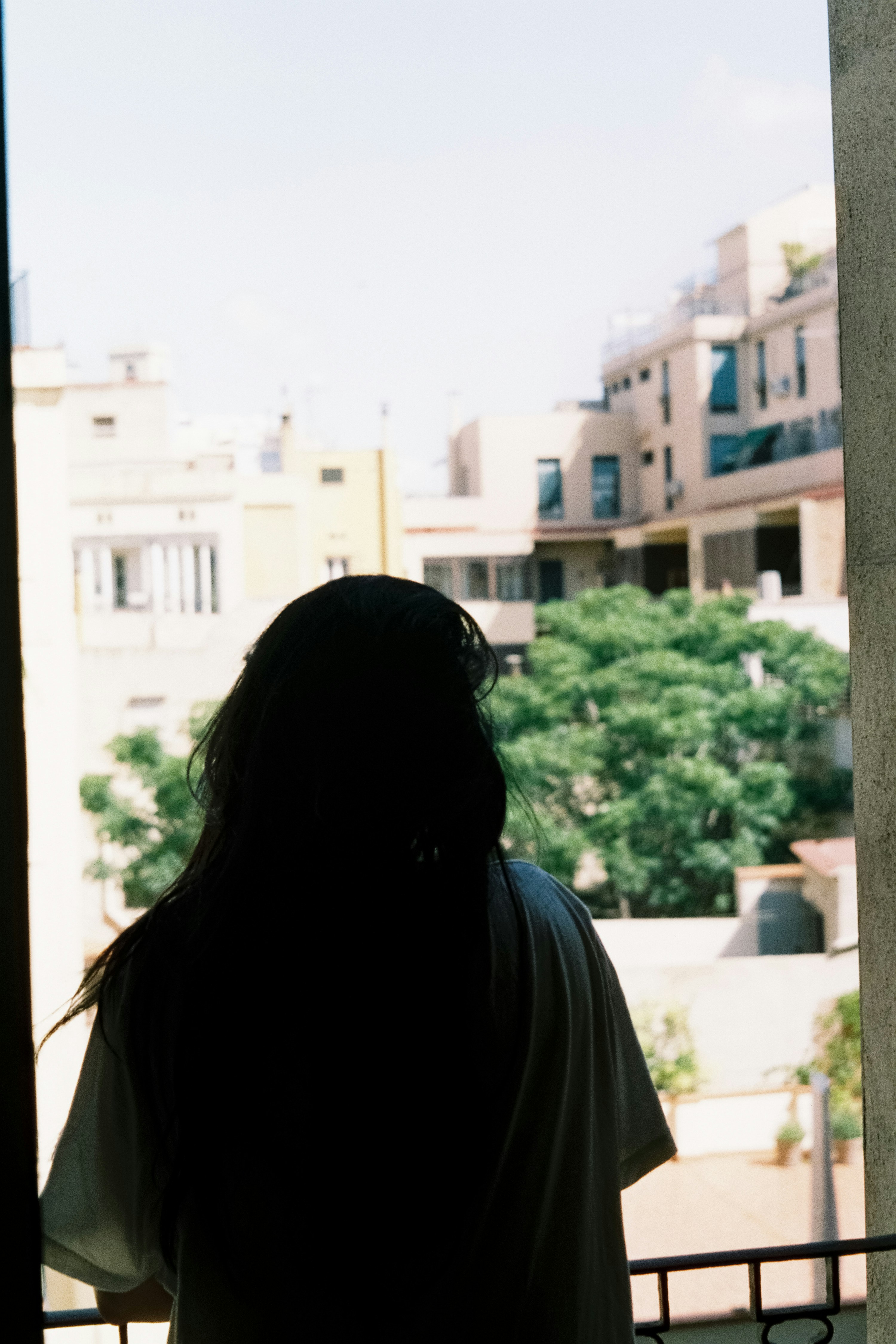 A woman standing in front of a window looking out photo – Free ...