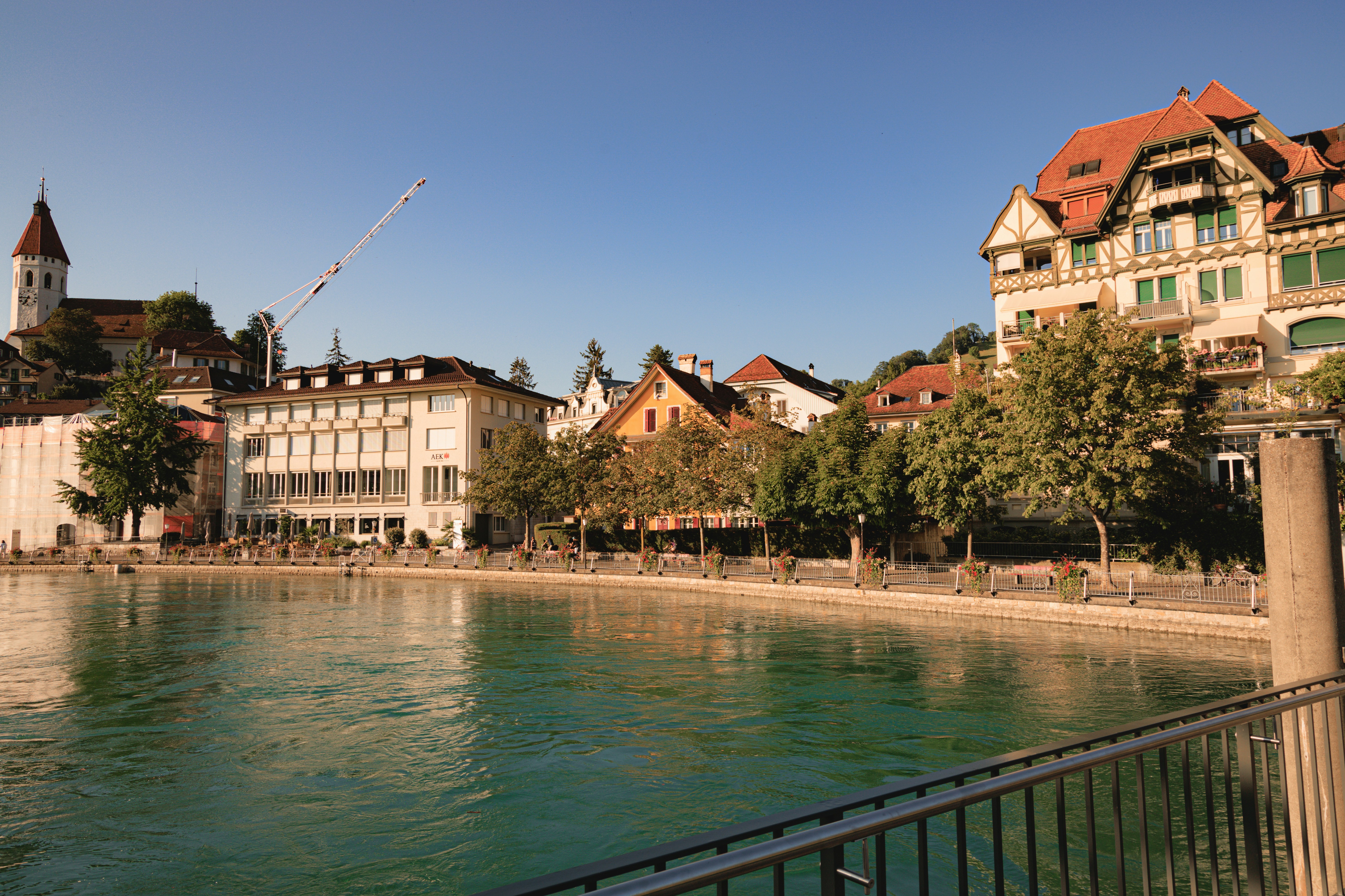 A river running through a city next to tall buildings photo – Free Thun ...
