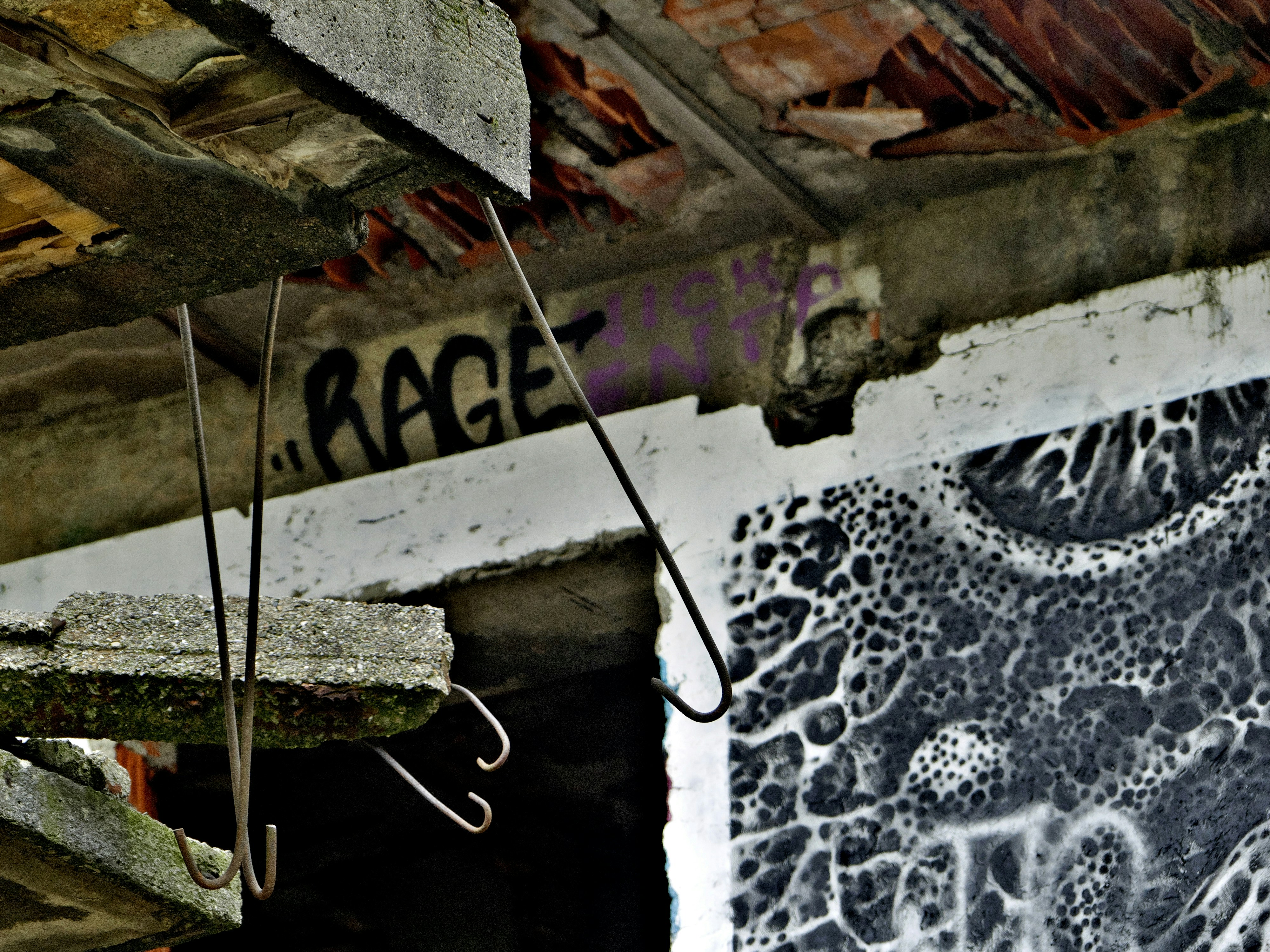 Hanging Hooks in a Crumbling Alcove: Concrete Fragments and Textured Wall