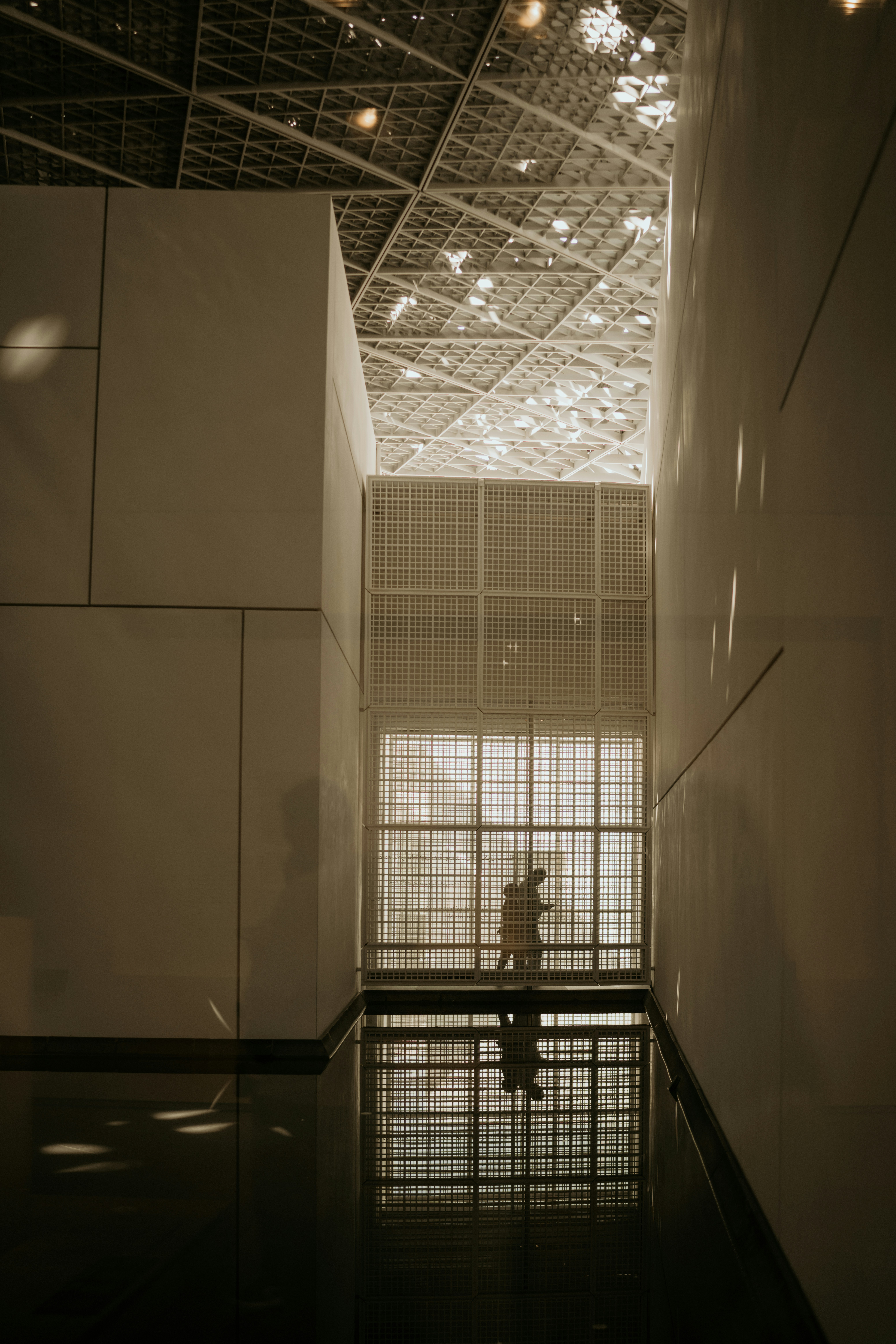 A person sitting on a bench in a dimly lit room photo – Free Abu dhabi ...