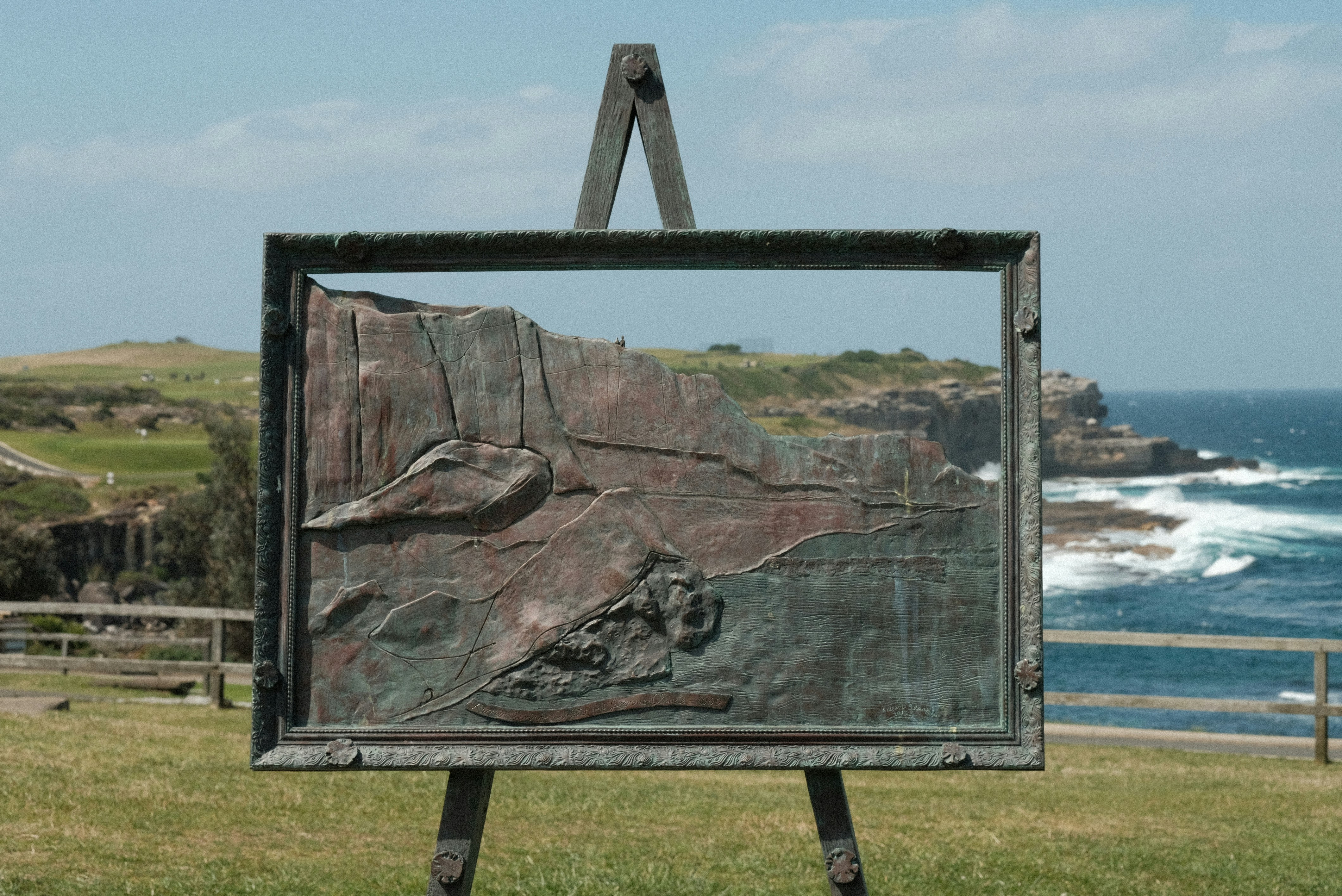Weathered Coastal Signboard Framed by Sea and Cliffs