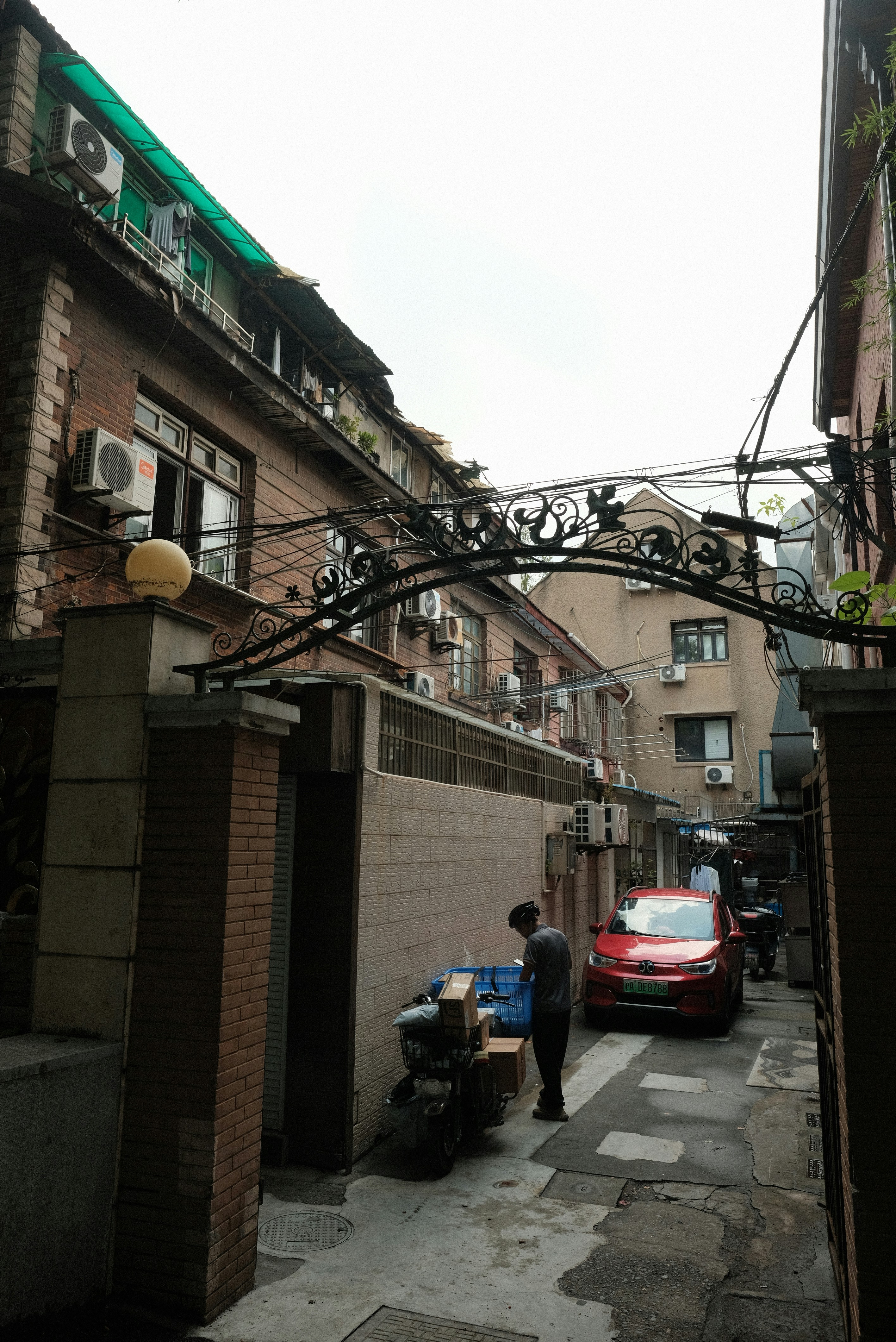 Narrow Alley Gate: Ironwork Arch Framing a Busy Urban Corridor