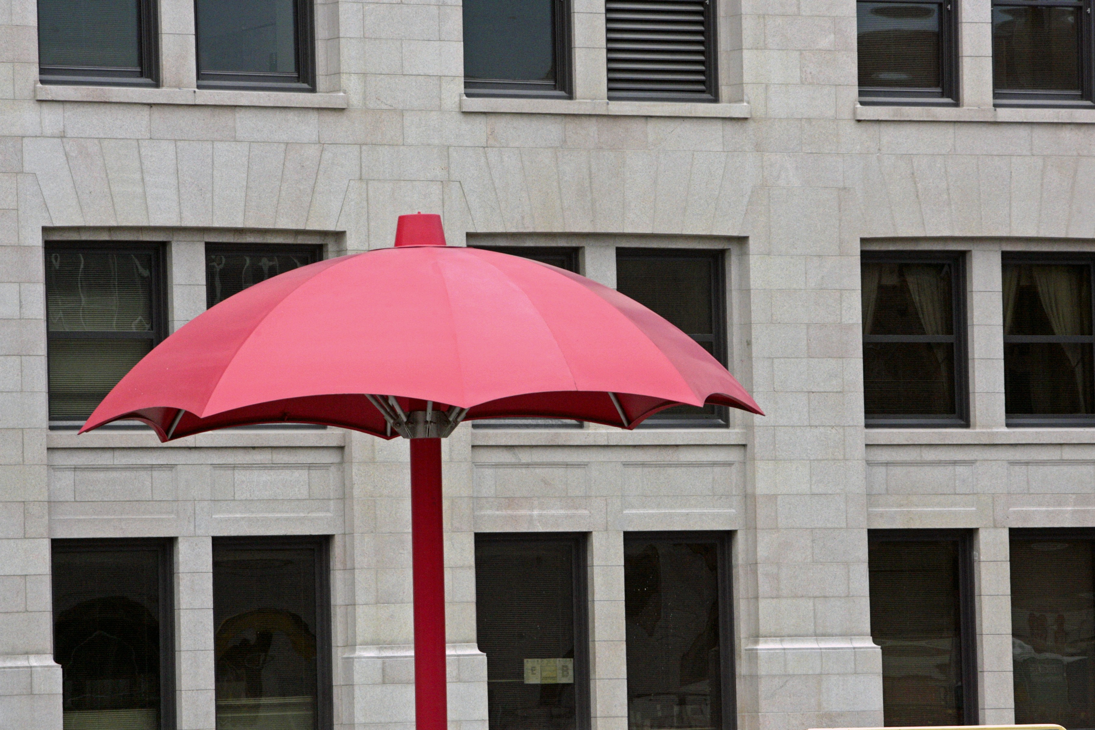 A red umbrella sitting in front of a building