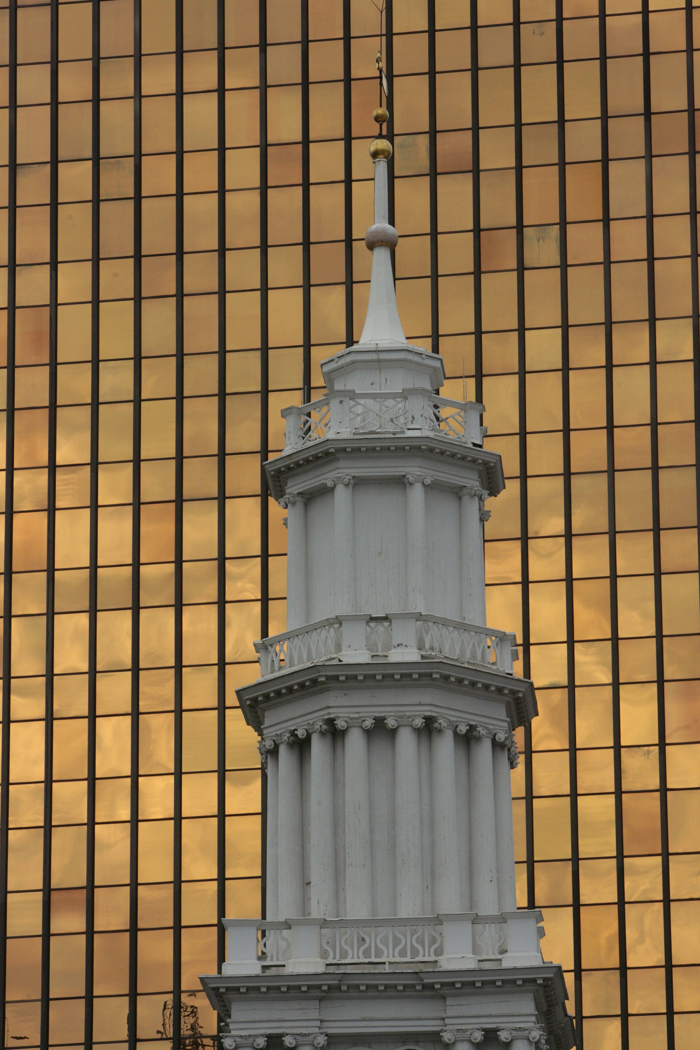 Neoclassical Spire Rising Before a Golden Glass Grid