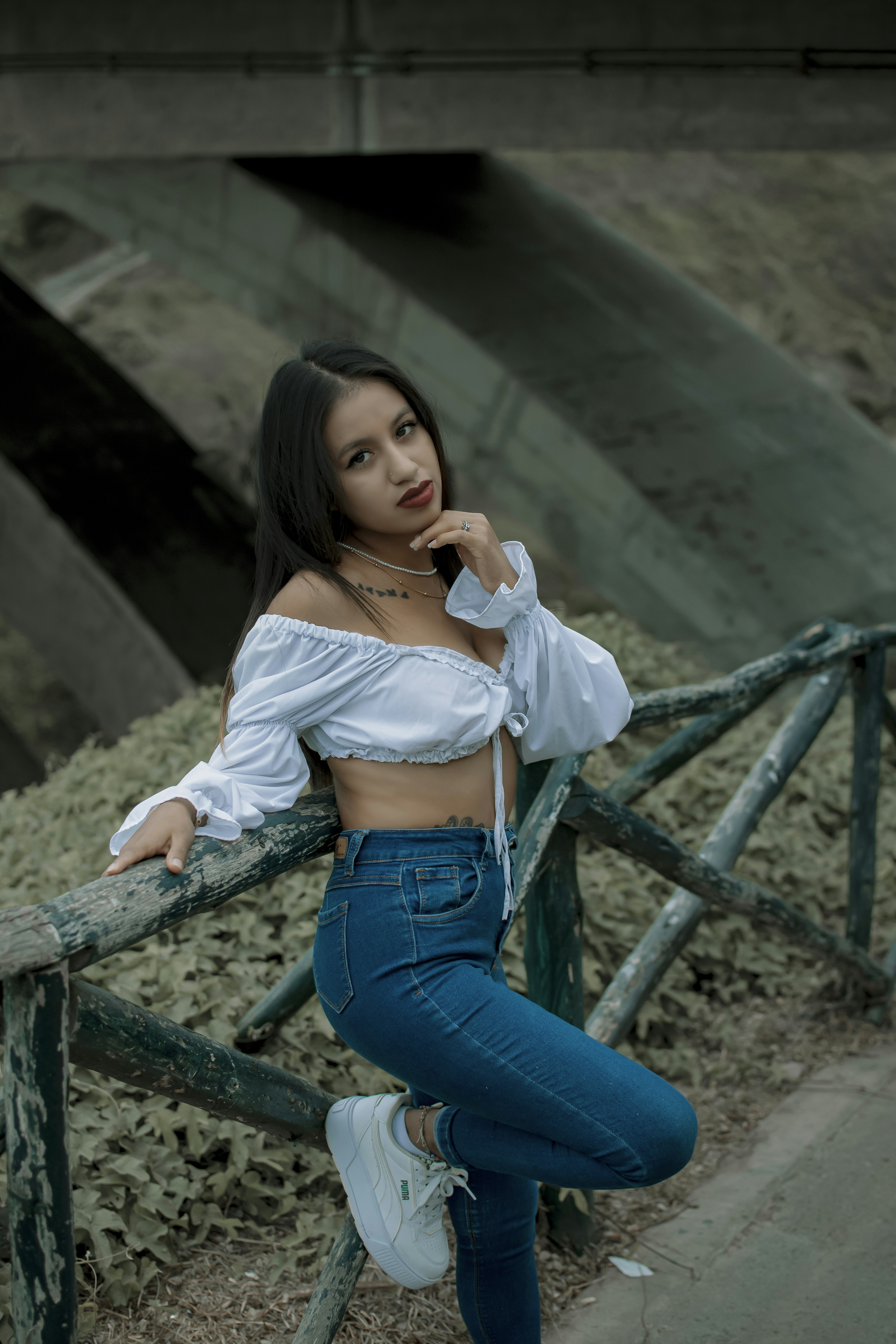 A woman leaning on a rail posing for a picture photo – Free Gente joven ...