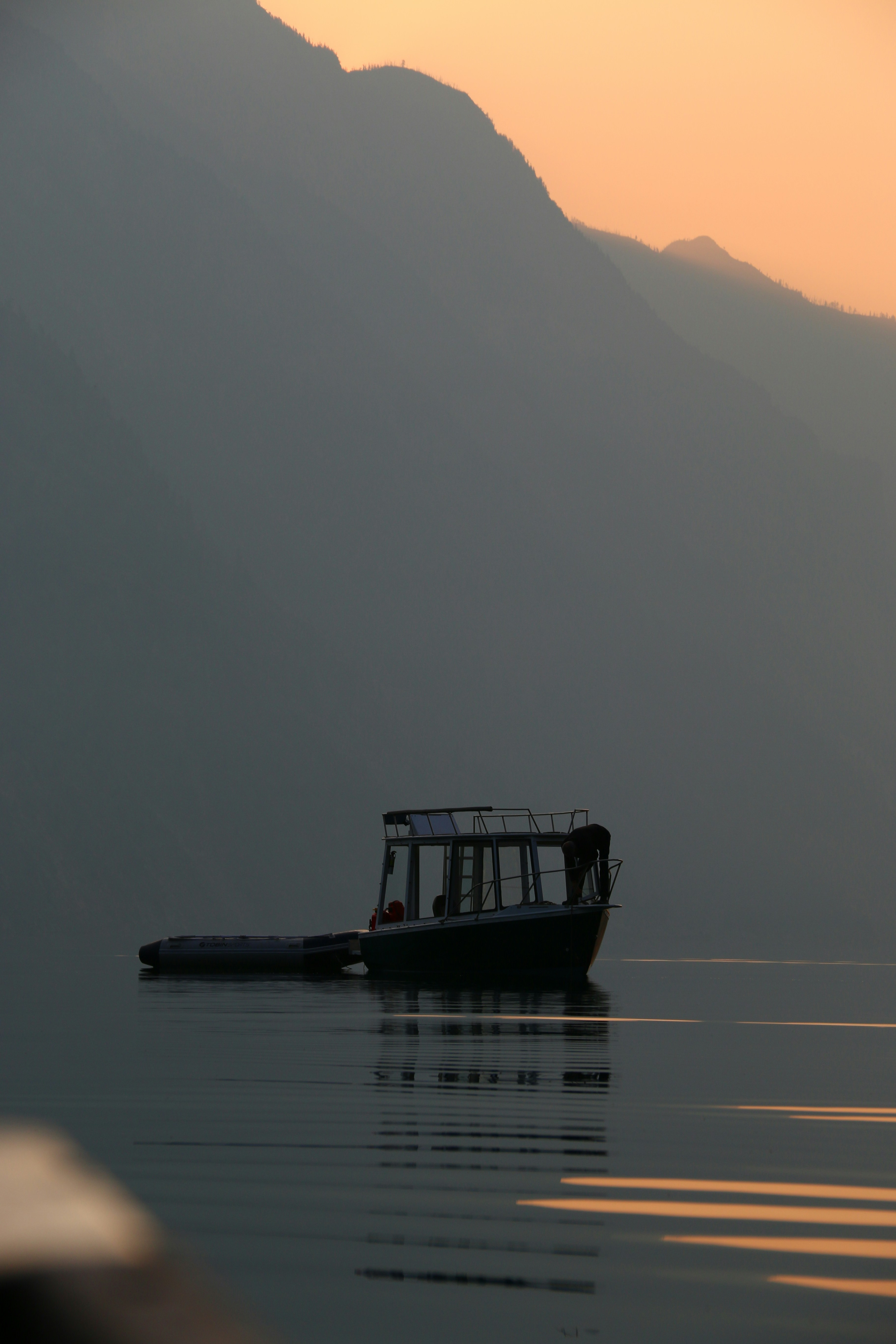 Dusk on a Glassy Fjord: A Lone Boat in Quiet Silhouette