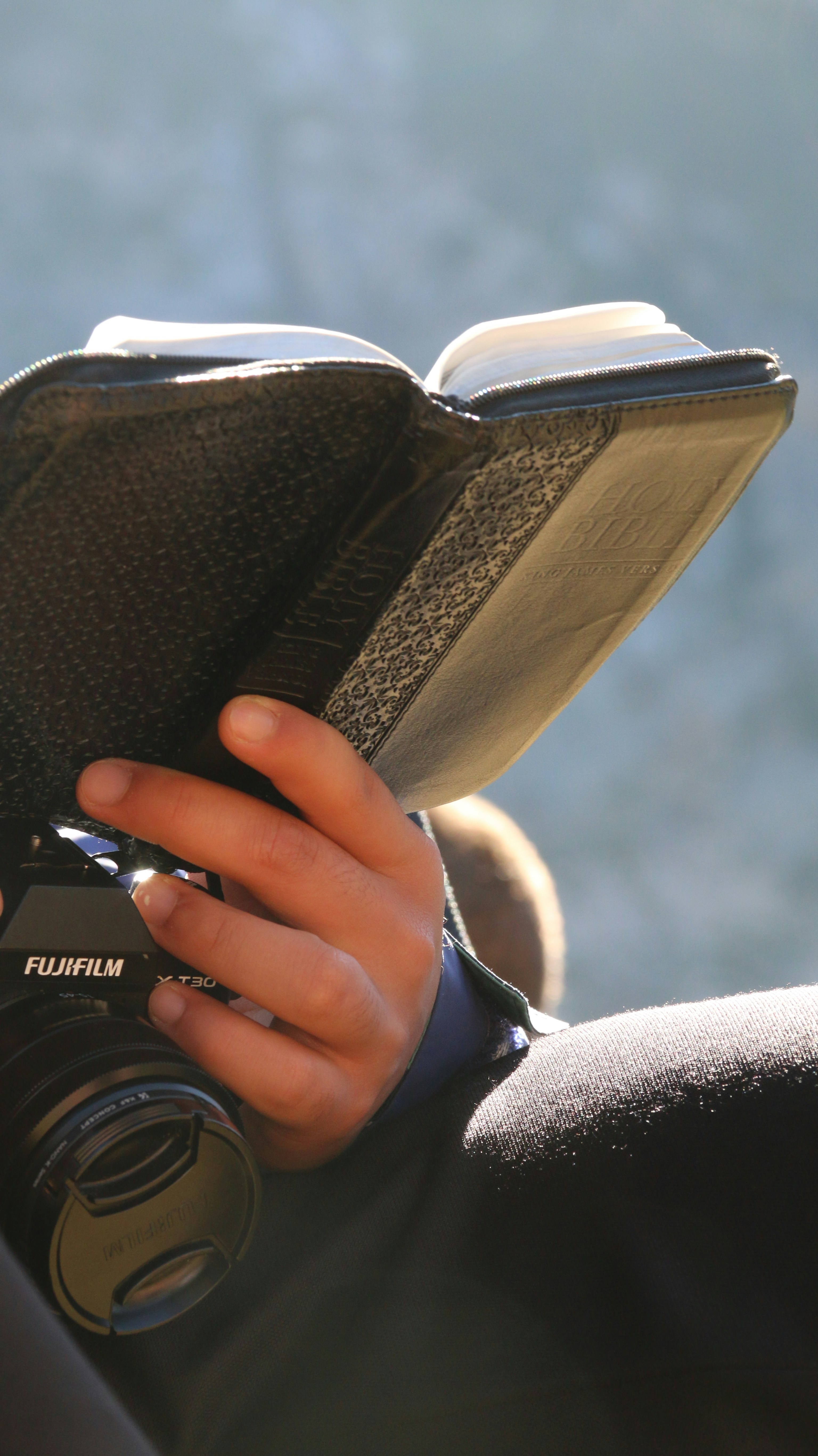Grasped in Light: A Hand, a Fujifilm, and an Open Book