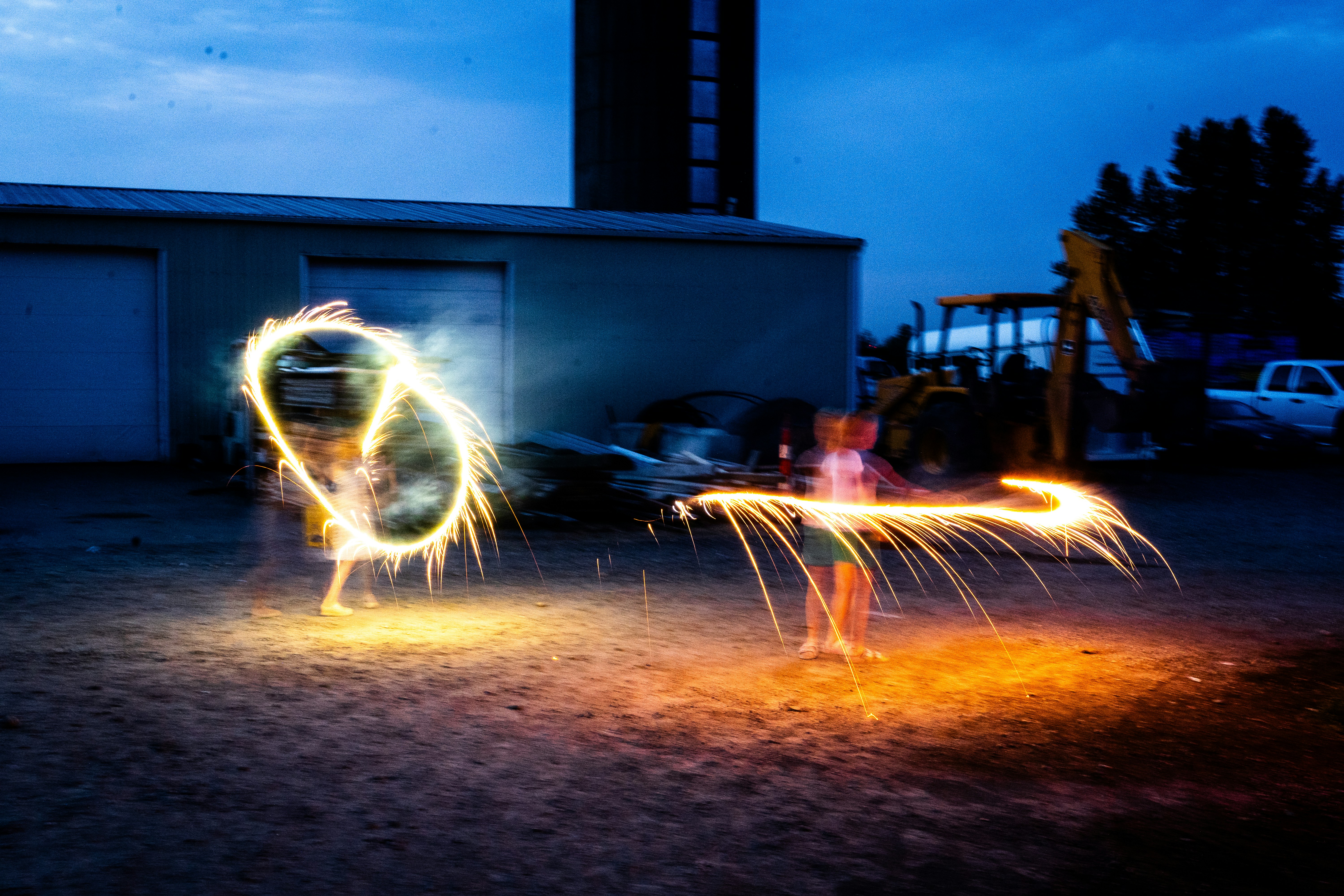 Firelight Whirls: Nighttime Sparks Around Moving Figures
