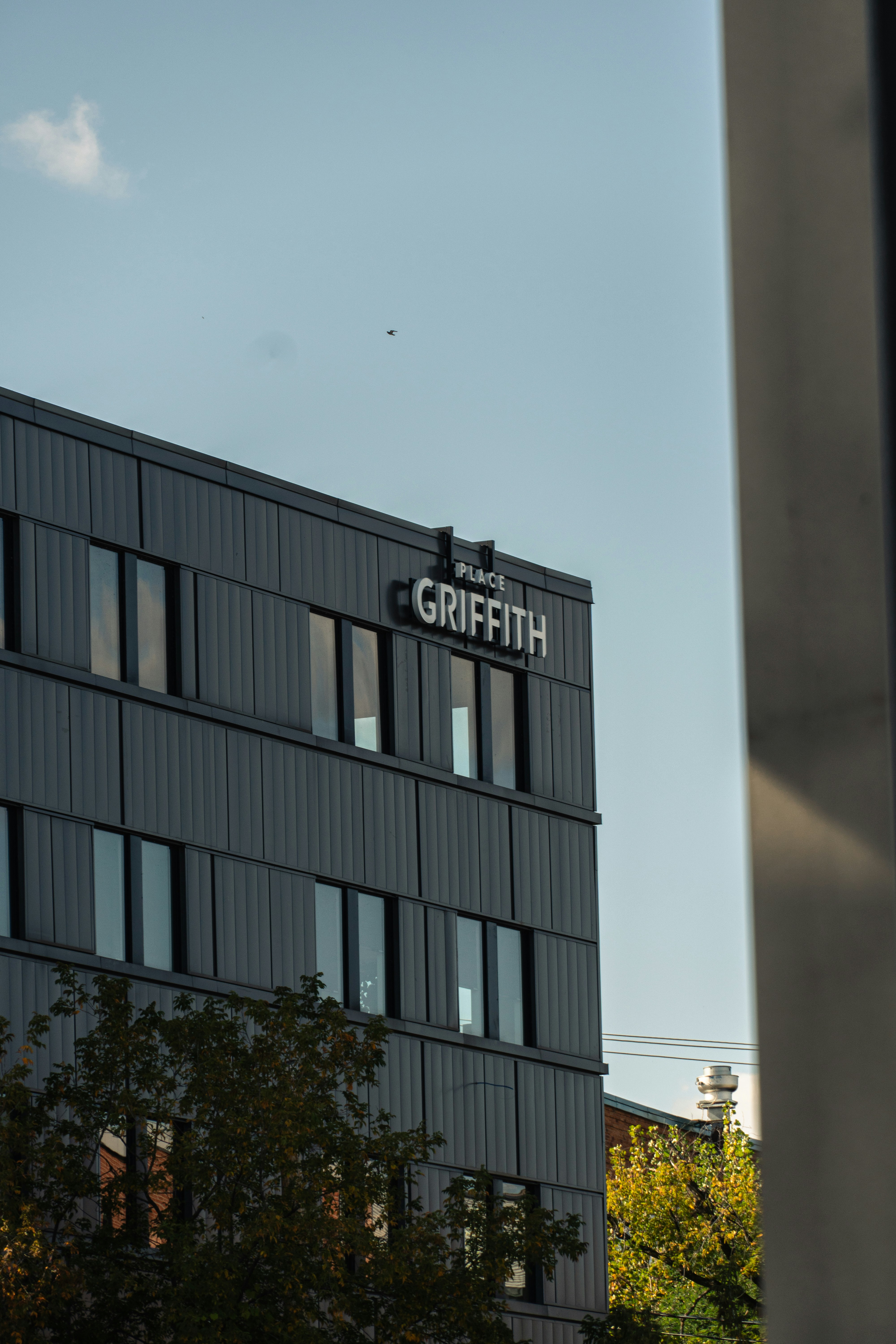 A tall building with a sign on the top of it photo – Free City Image on ...