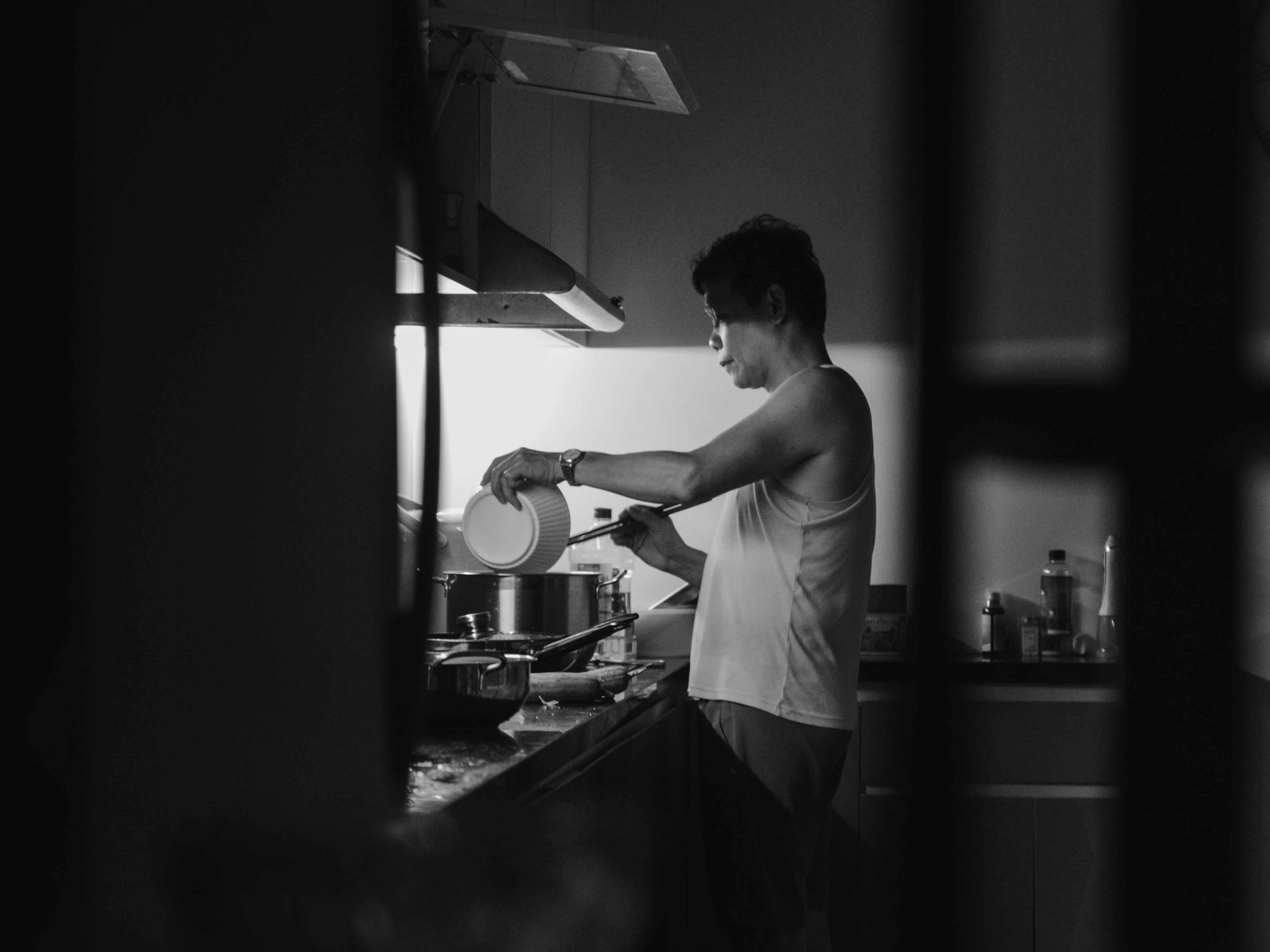 A man standing in a kitchen preparing food photo – Free Human Image on ...
