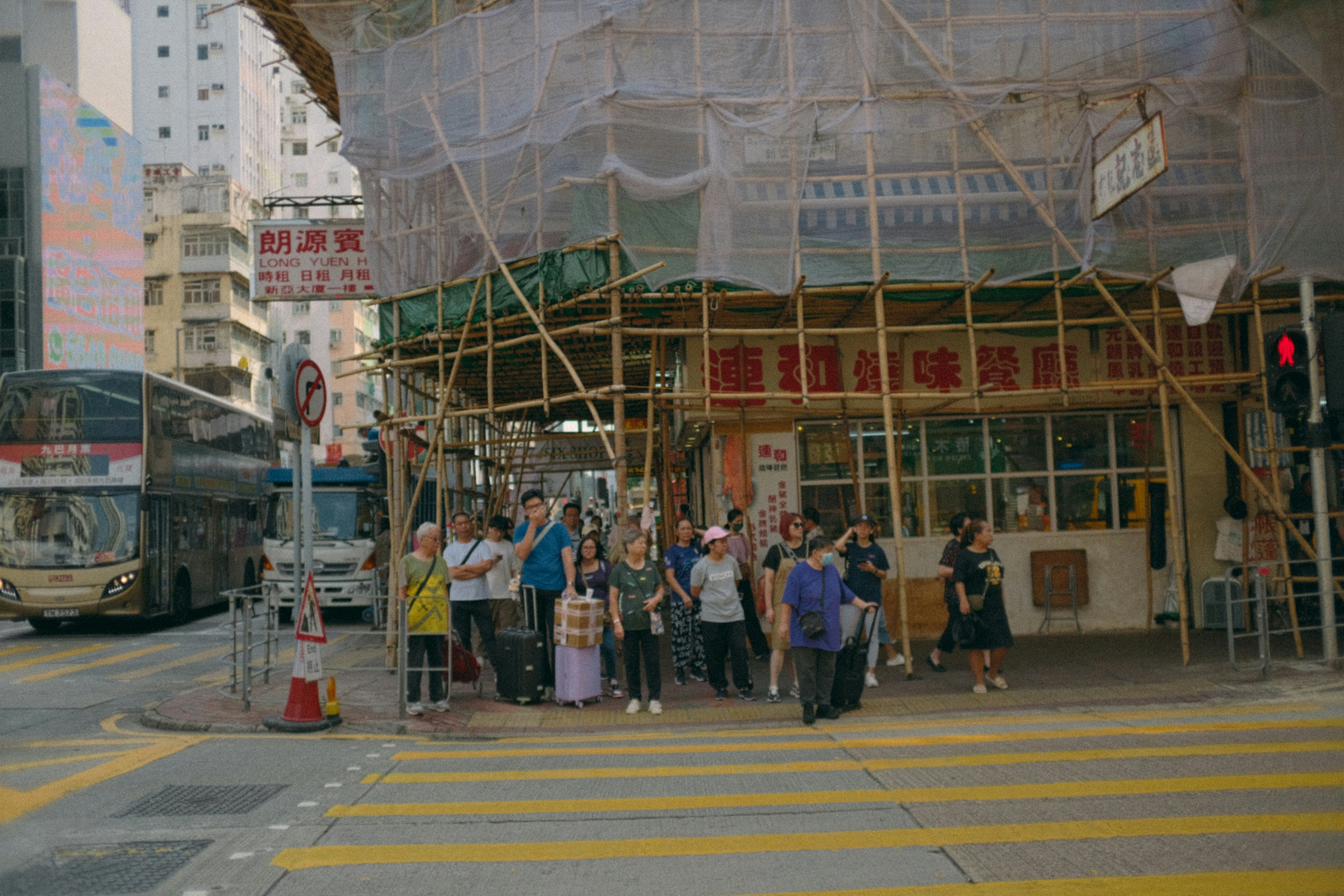Crosswalk Congregation in Front of a Building Wrapped in Scaffolding