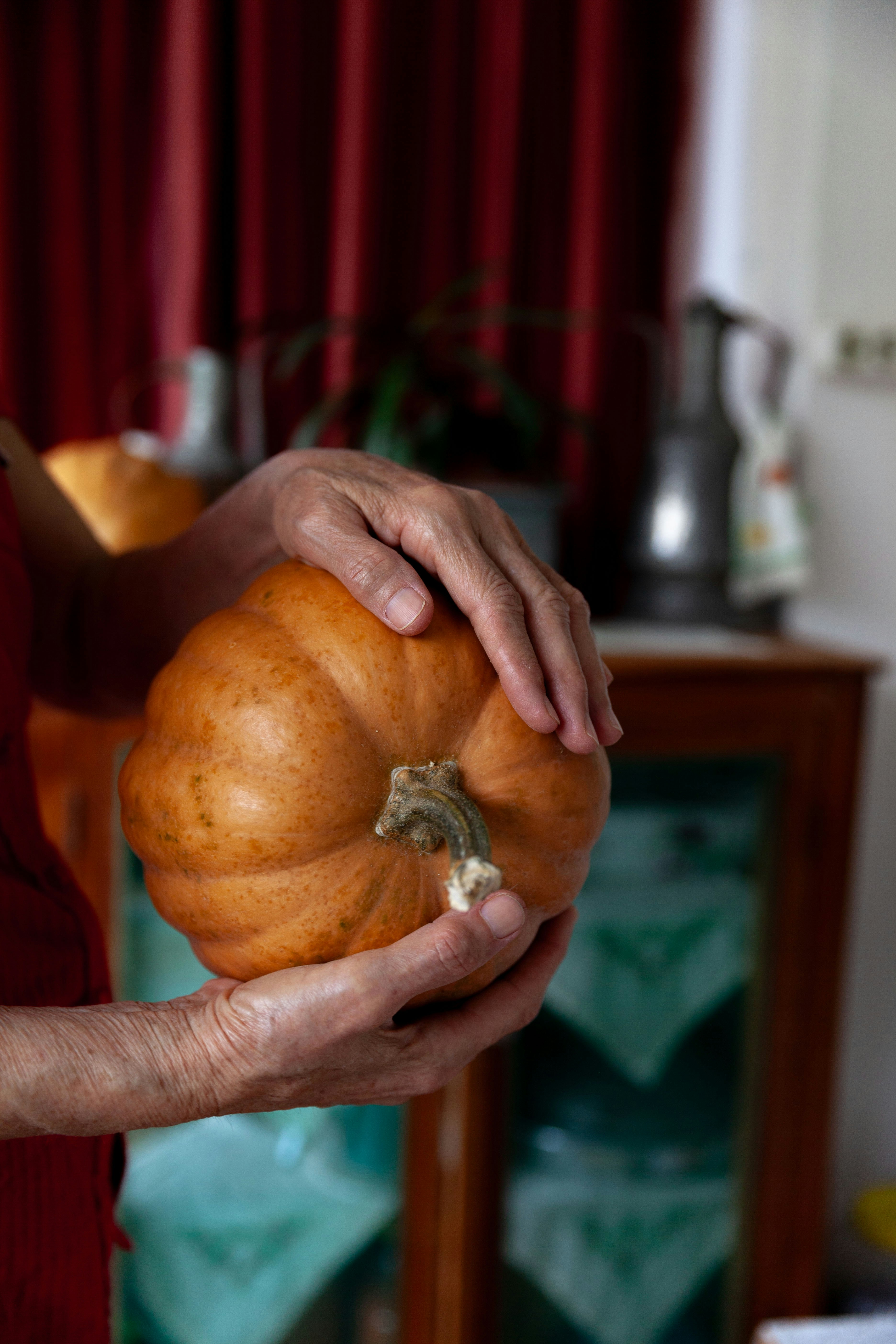 Holding a Small Pumpkin, A Quiet Kitchen Moment