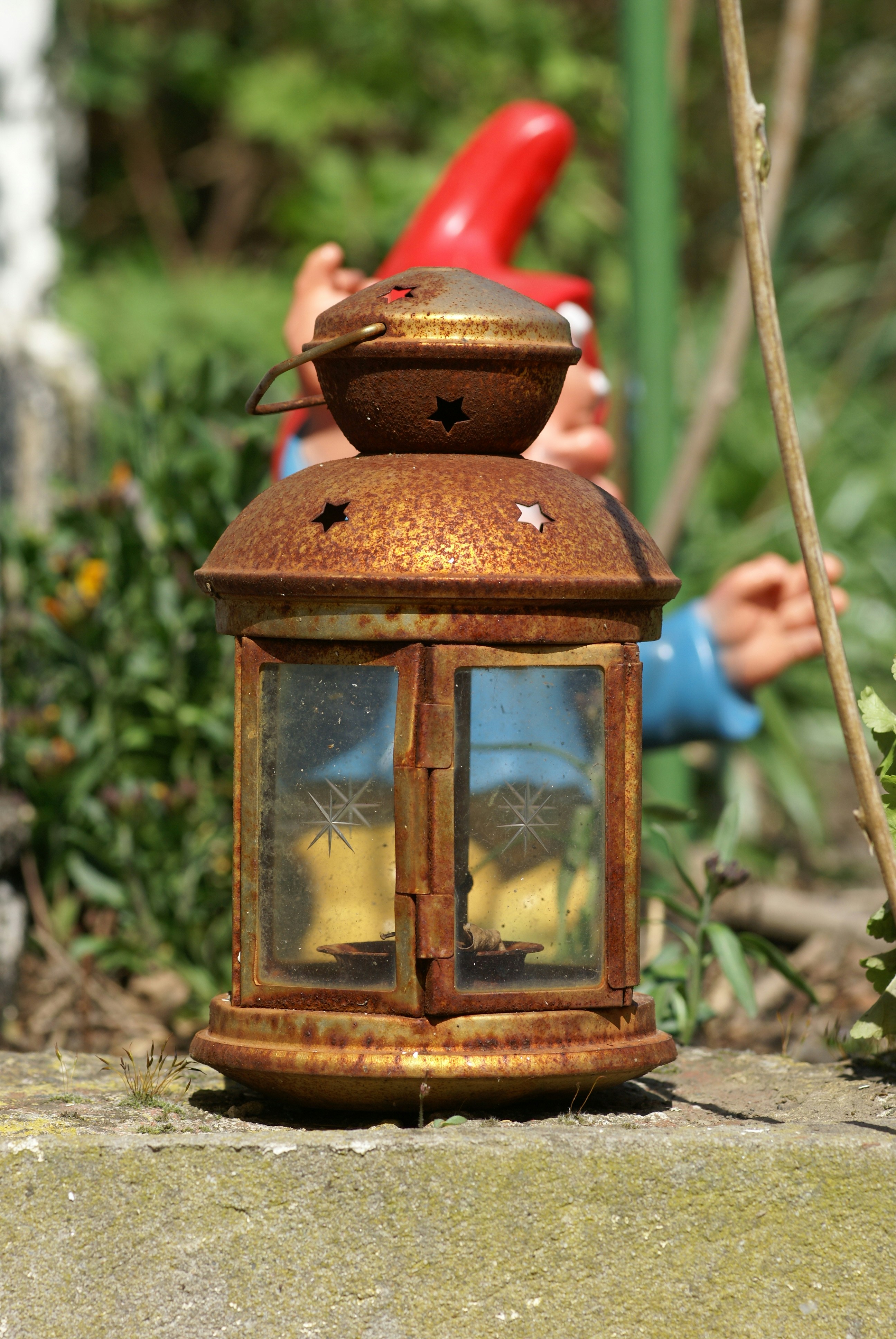 Weathered Lantern with Star Openings on a Sunlit Garden Ledge