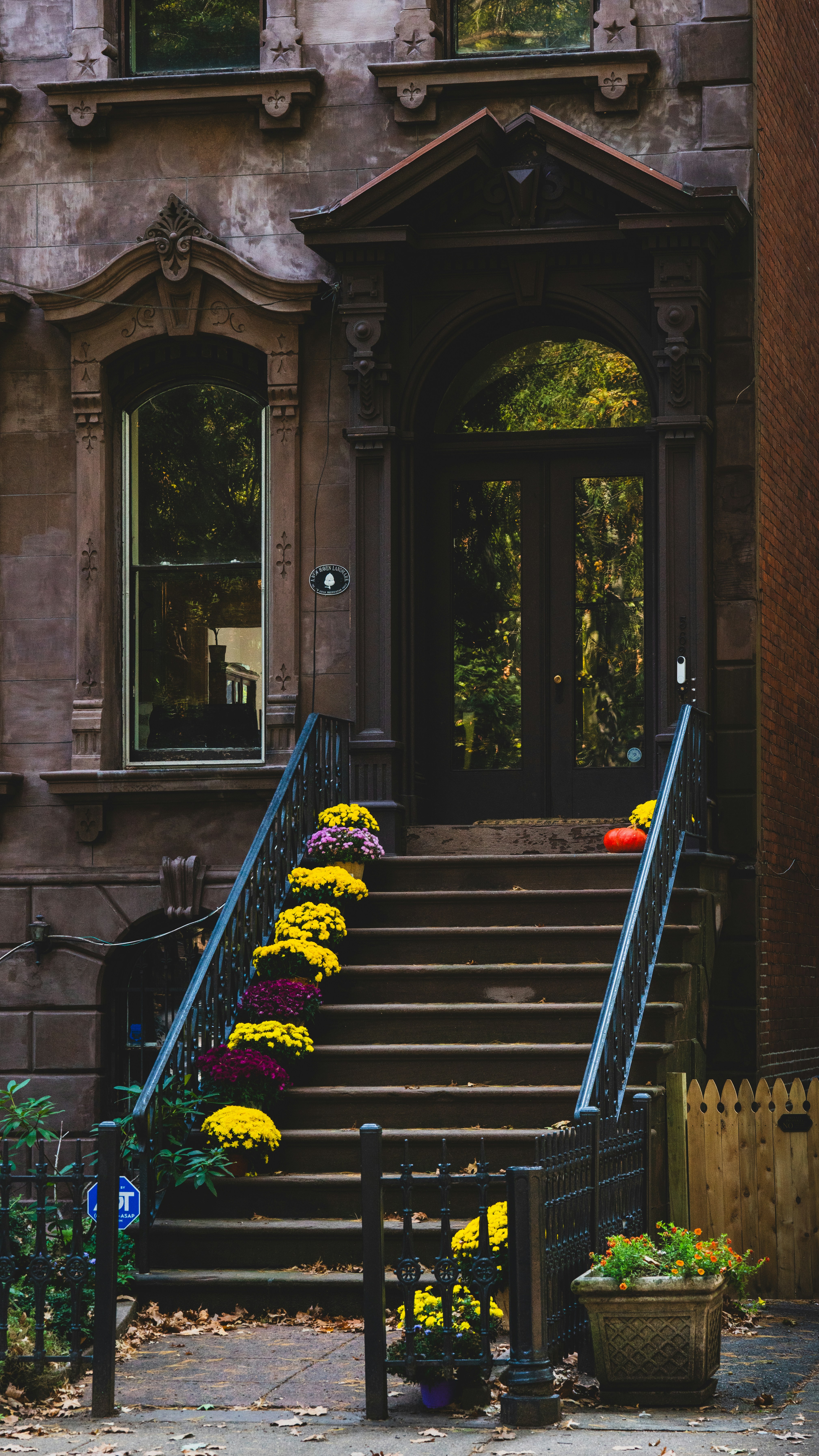 A building with a bunch of flowers on the steps photo – Free Stairs ...
