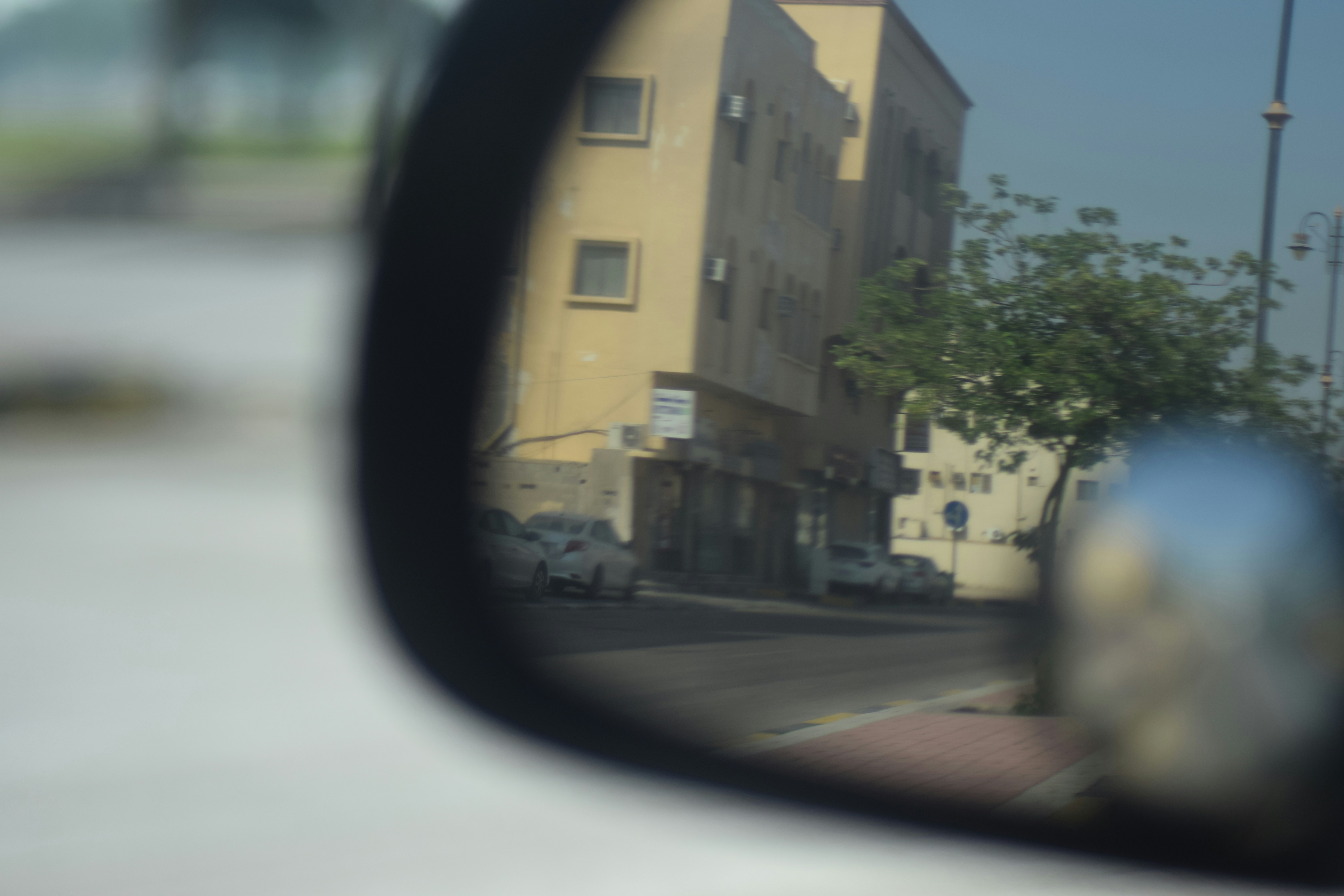 Rear-View Cityscape: A Sunlit Facade Framed in Glass