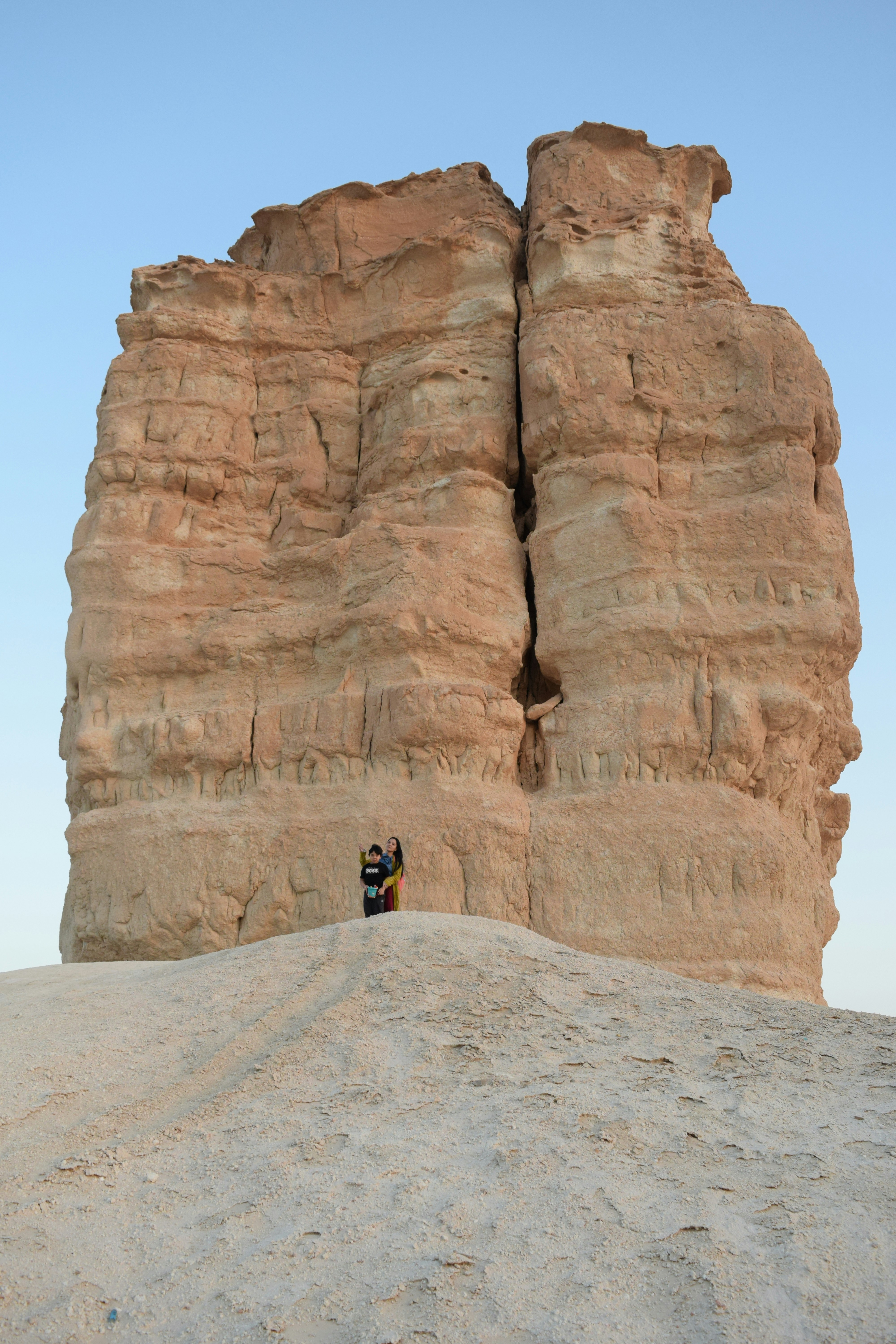 Two Climbers at the Foot of a Twin Sandstone Spire Under a Cerulean Sky