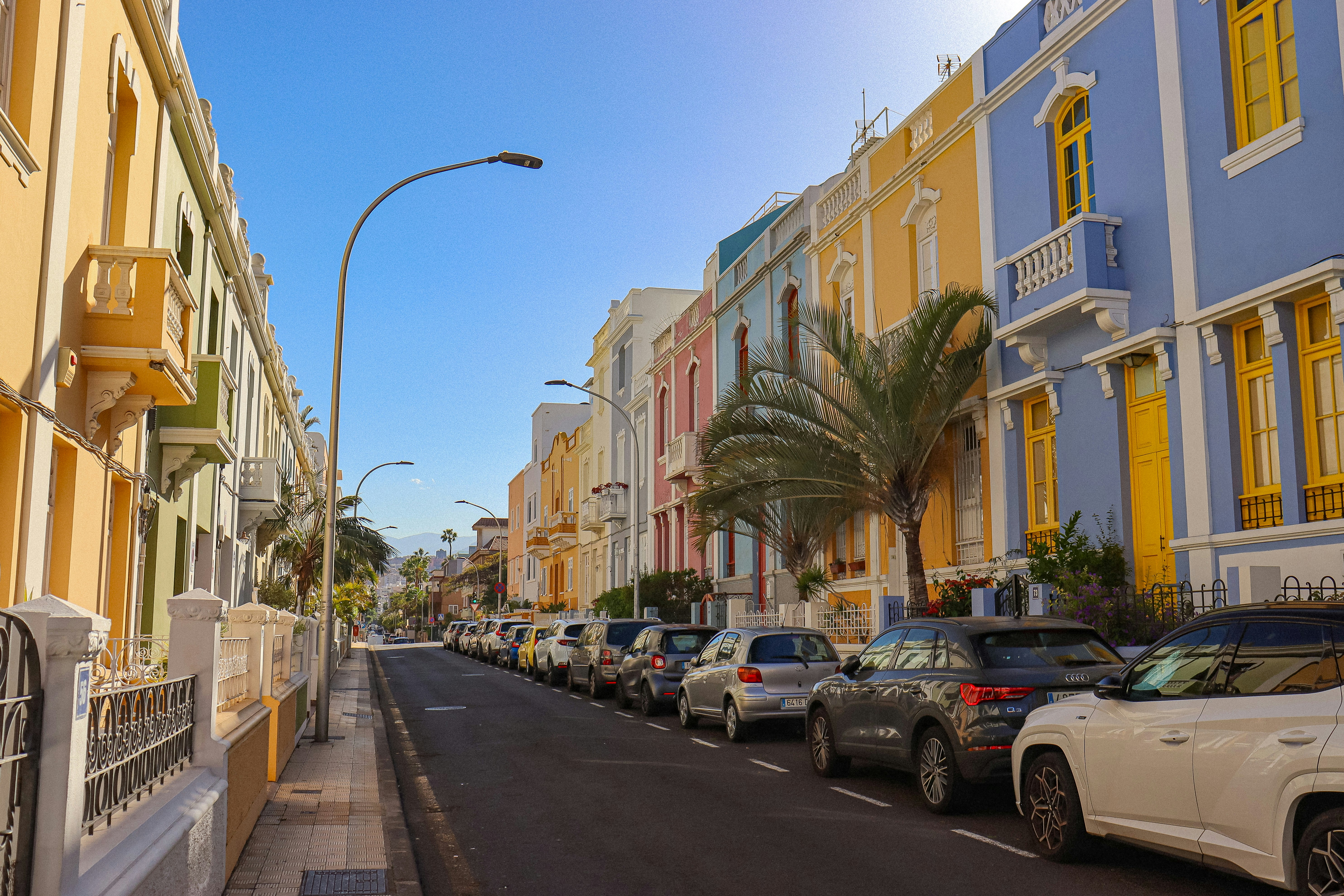 Colorful Seaside Street: A Row of Pastel Townhouses and Parked Cars