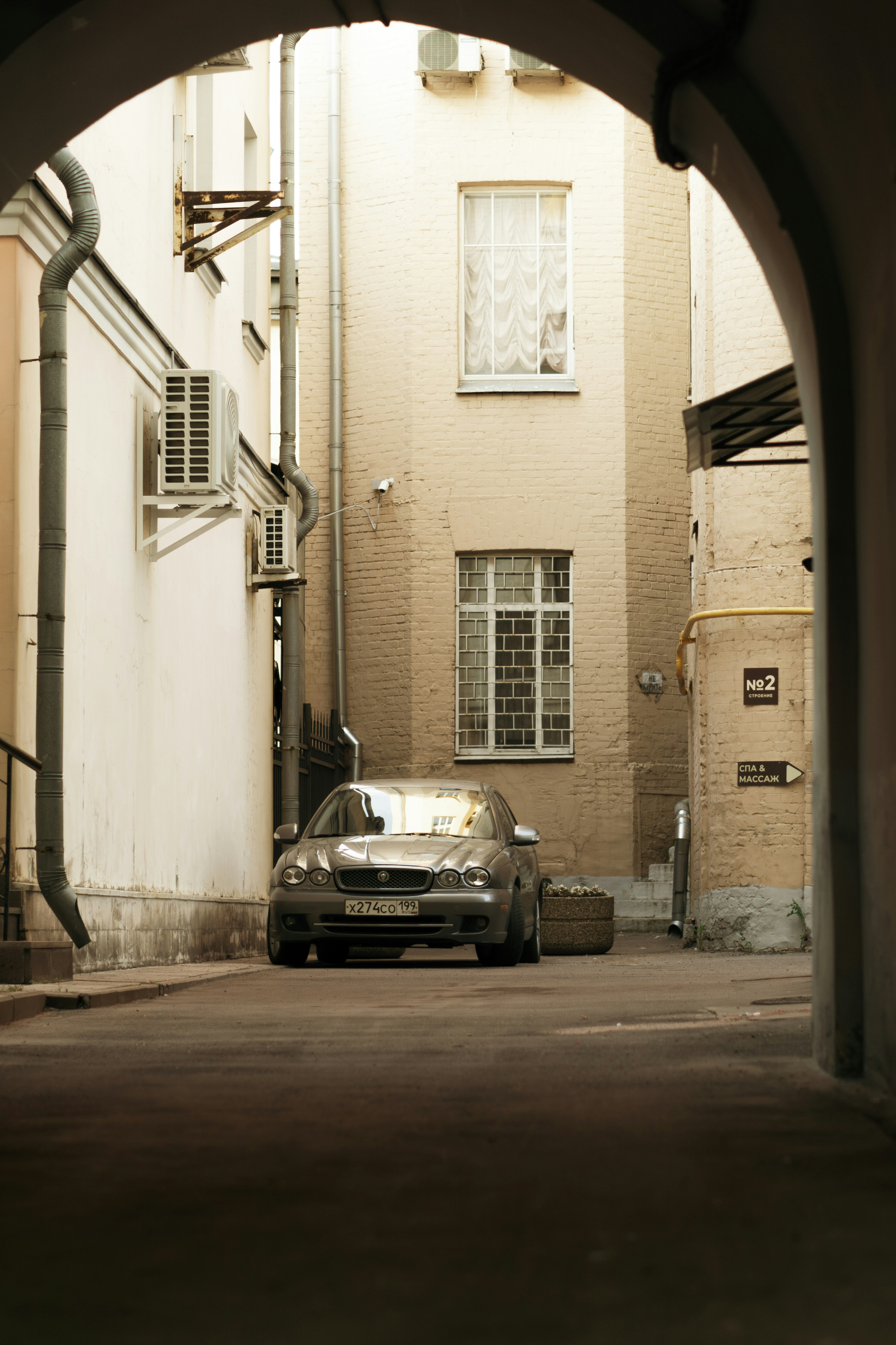 A car is parked in an alley between two buildings photo – Free Street ...