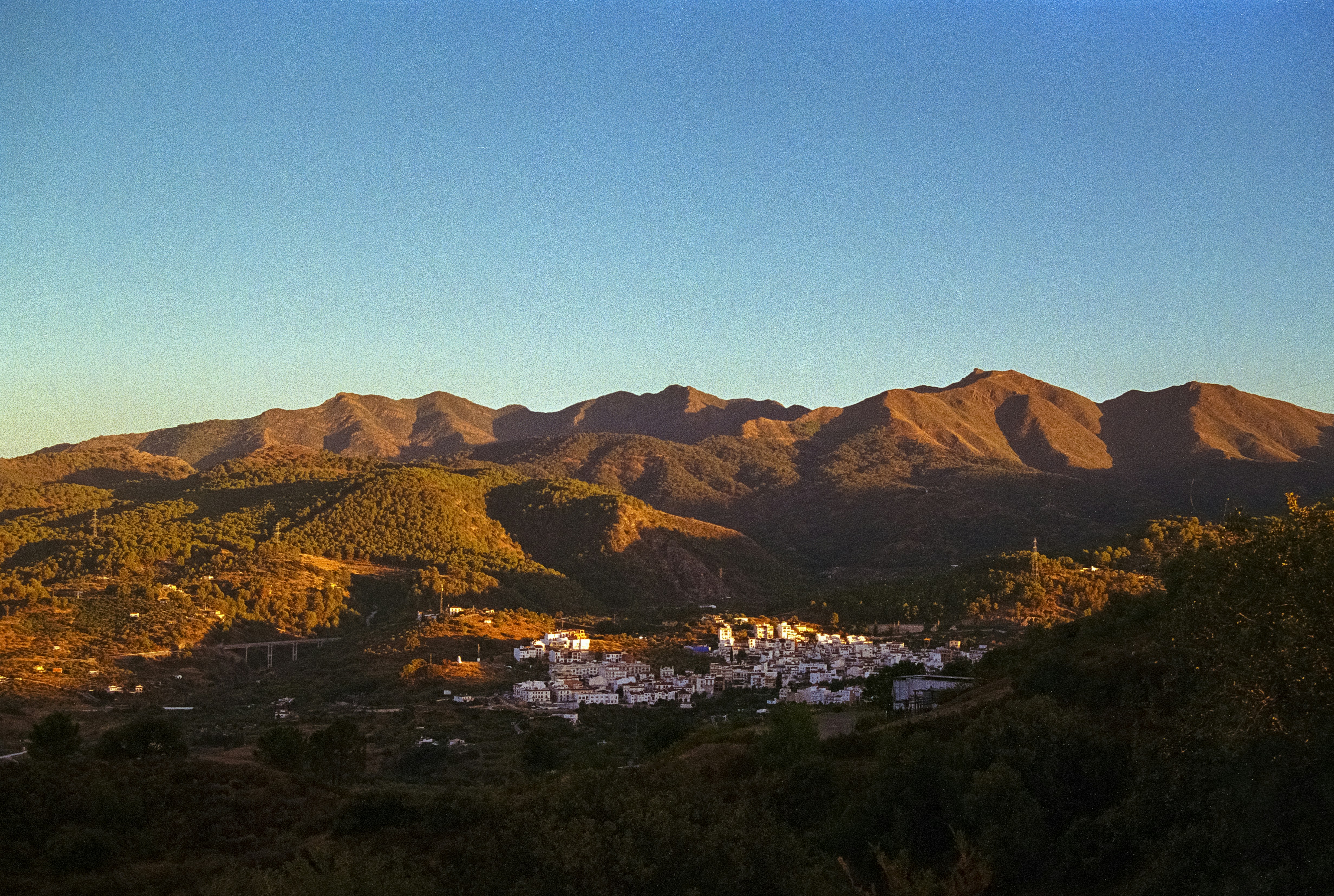 A view of a mountain range with a town in the foreground photo – Free ...