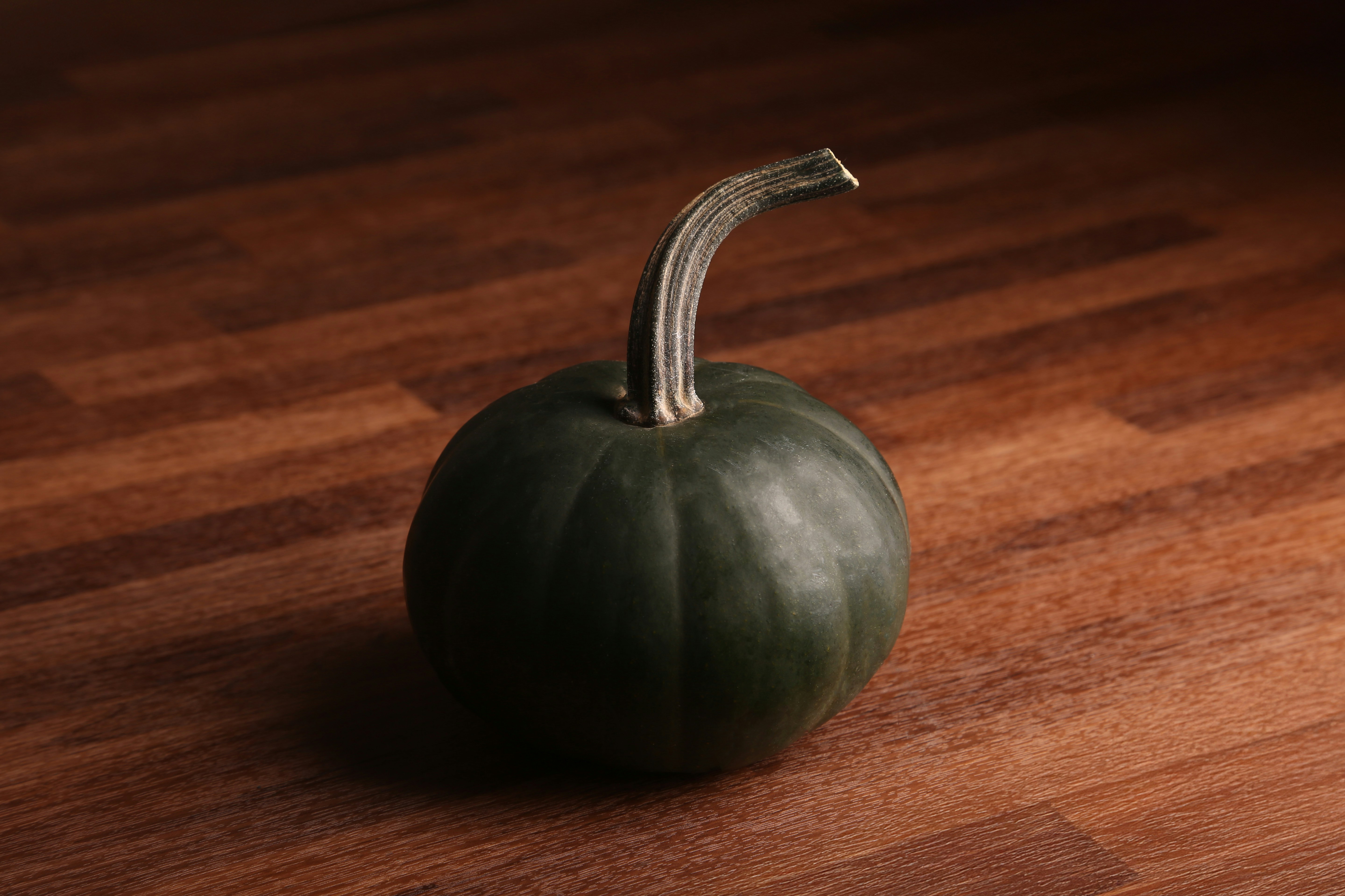 Midnight-green Pumpkin on Raced Wood