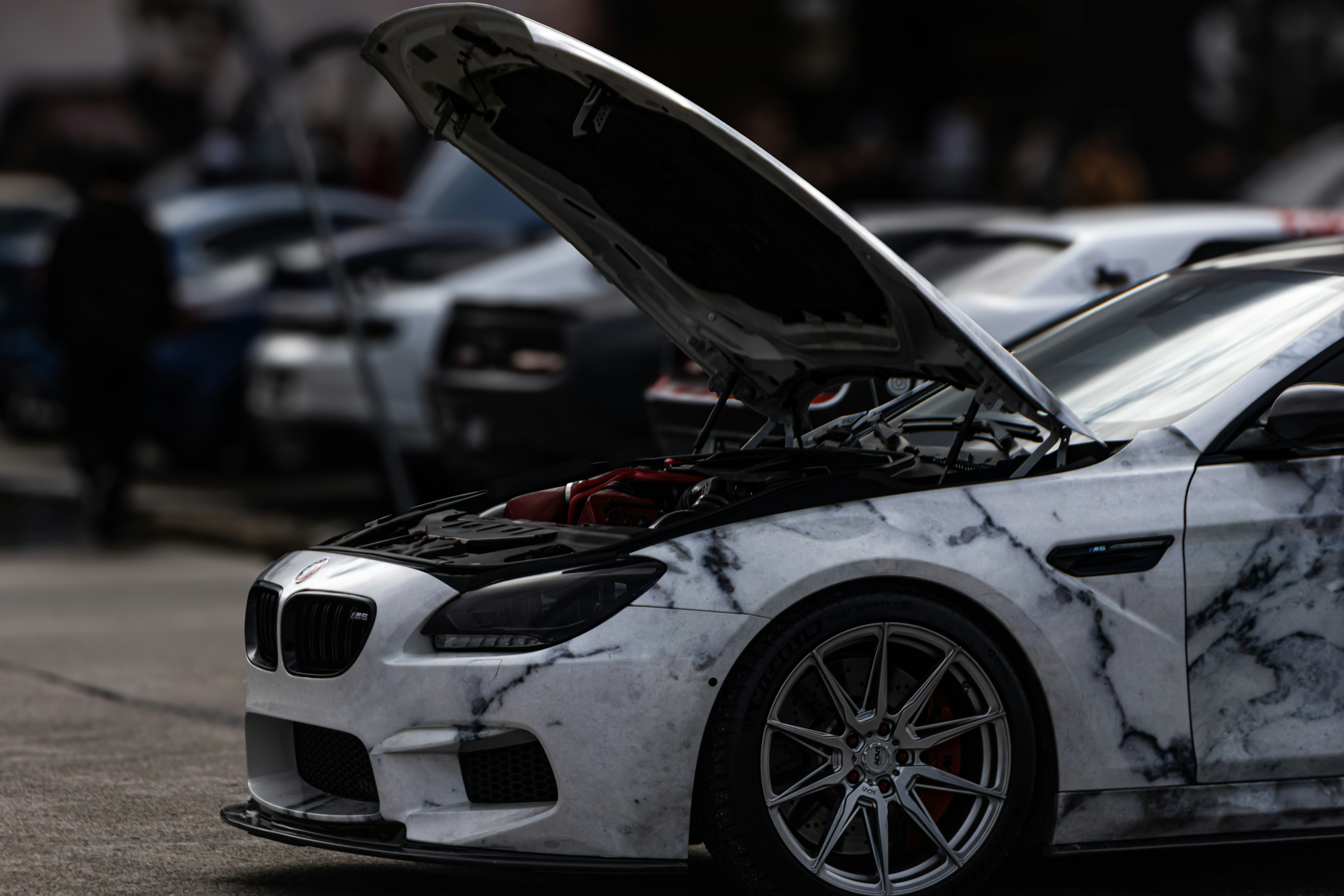 Raised Hood, Marble Finish: A Drifted Car Under Show Lights