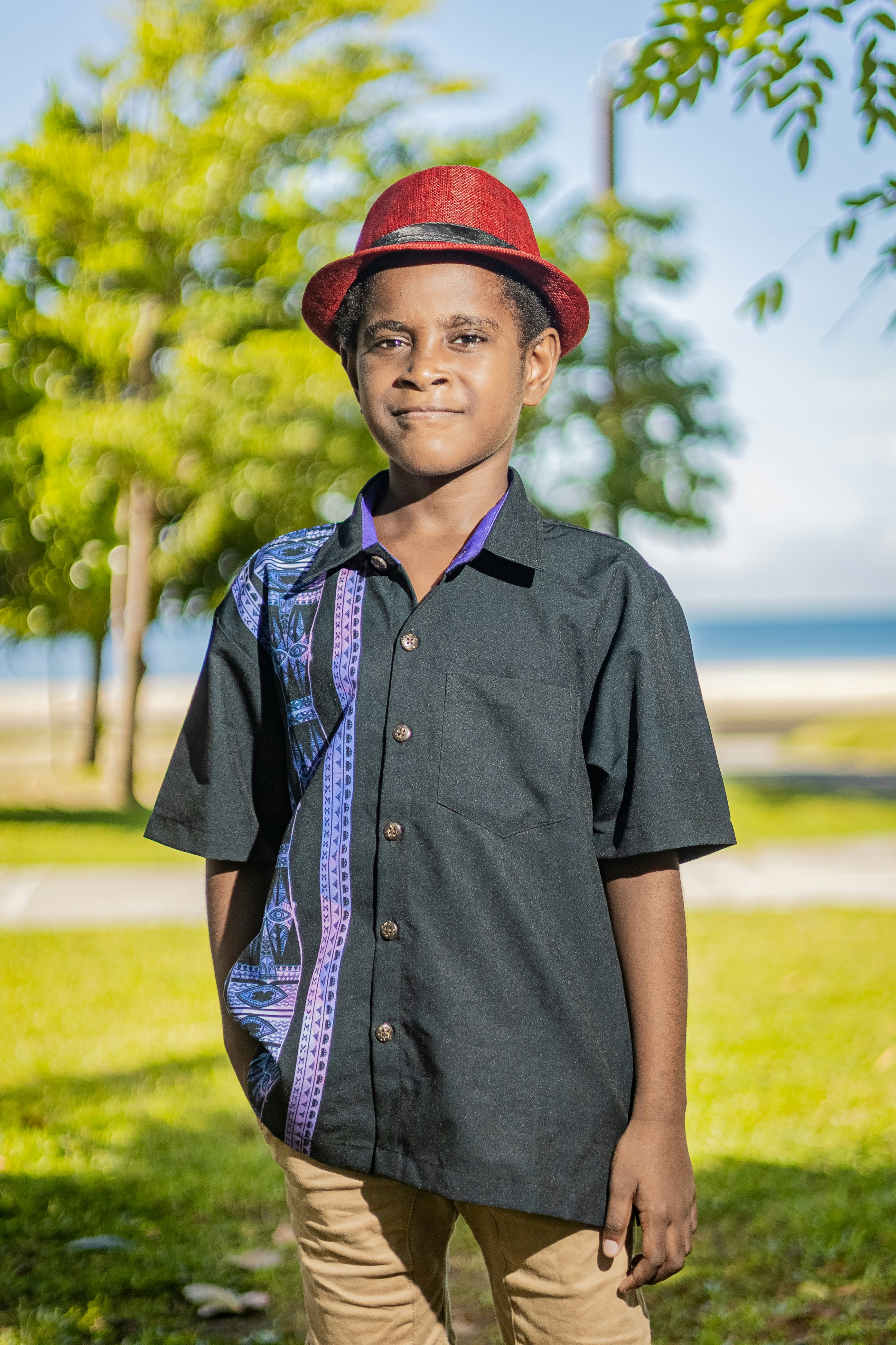 Red Hat, Bright Light: A Confident Portrait in a Seaside Park