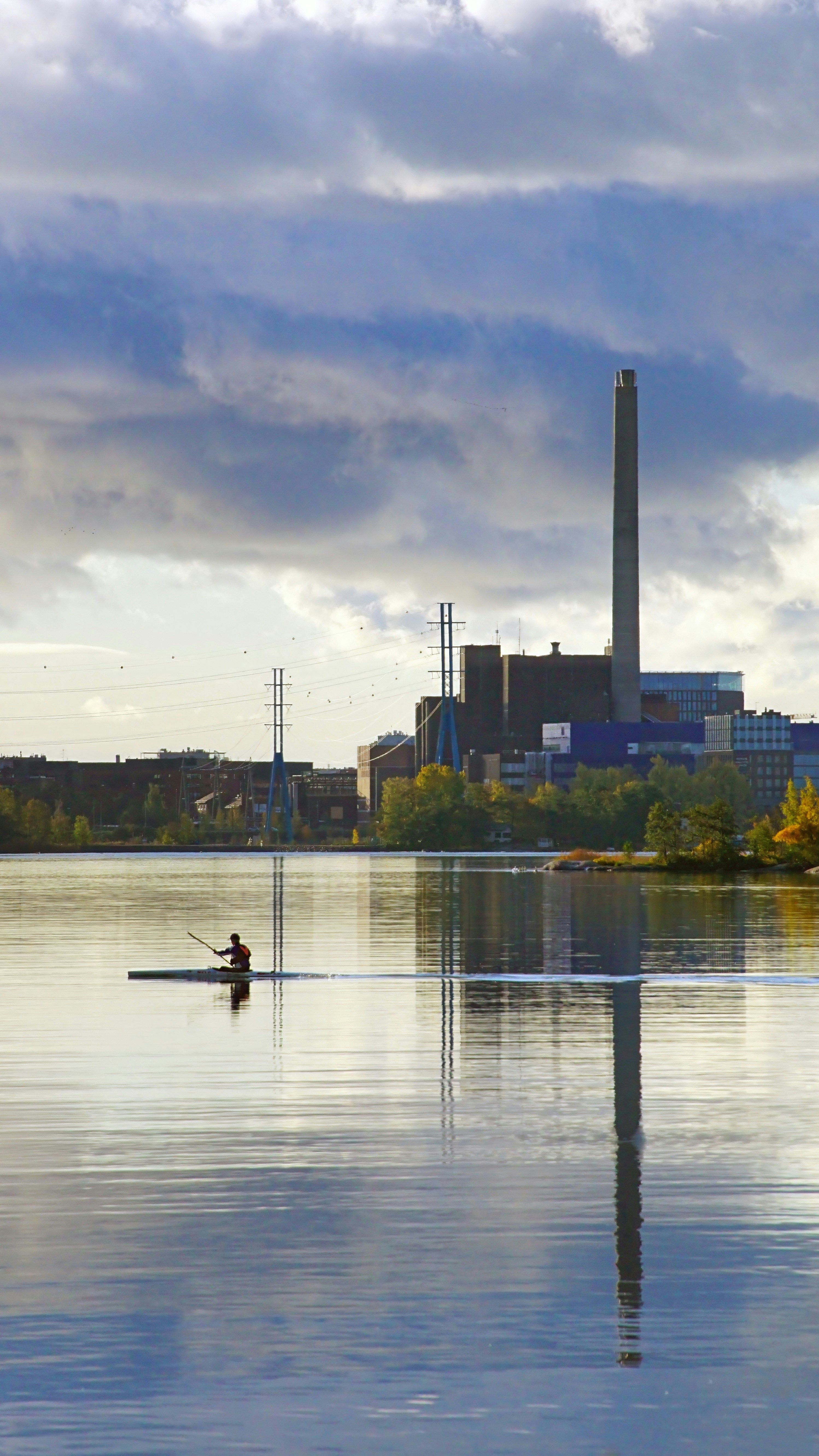 Glassy River, Lone Rower, and a Monolithic Skyline