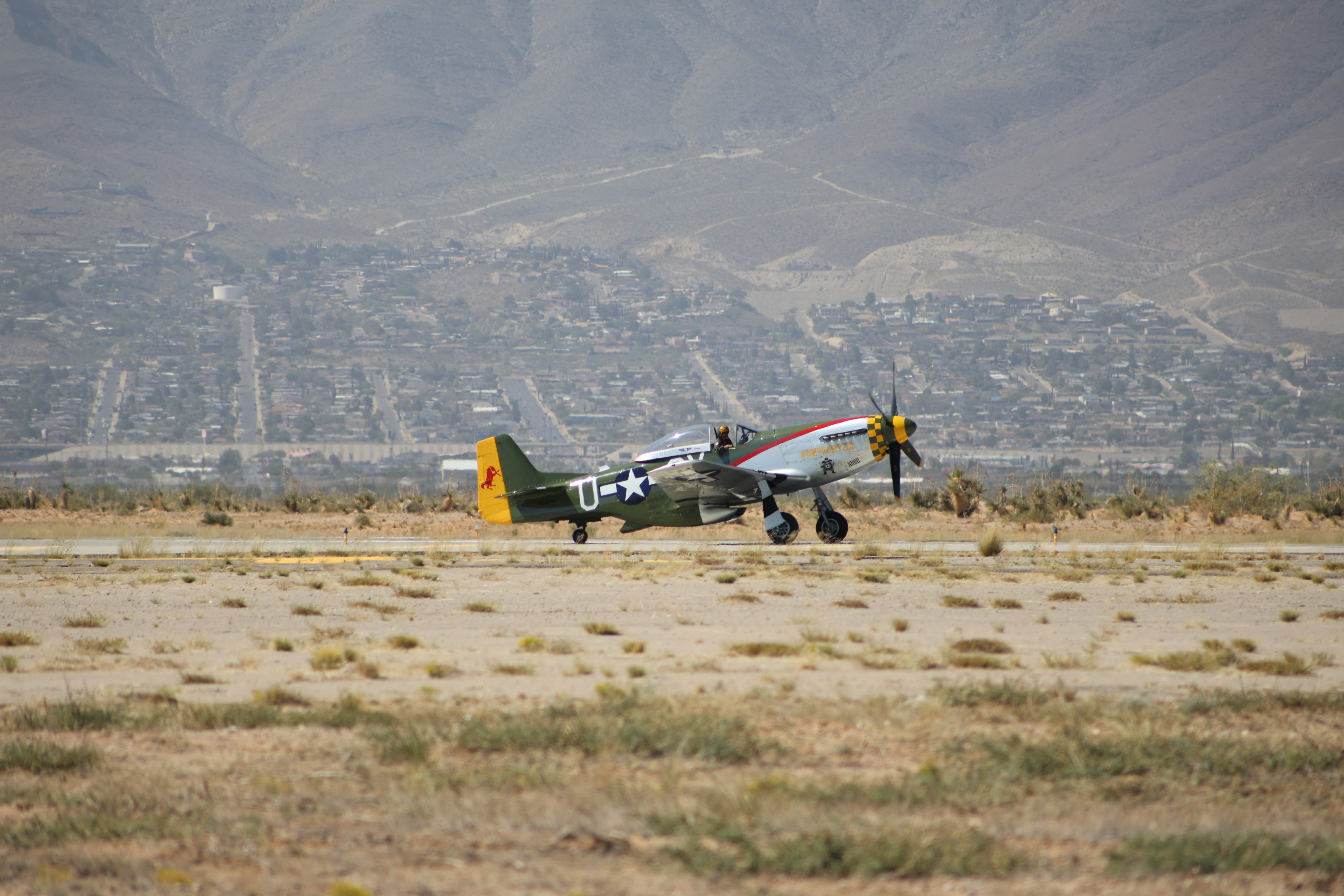 A small airplane sitting on top of a dry grass field
