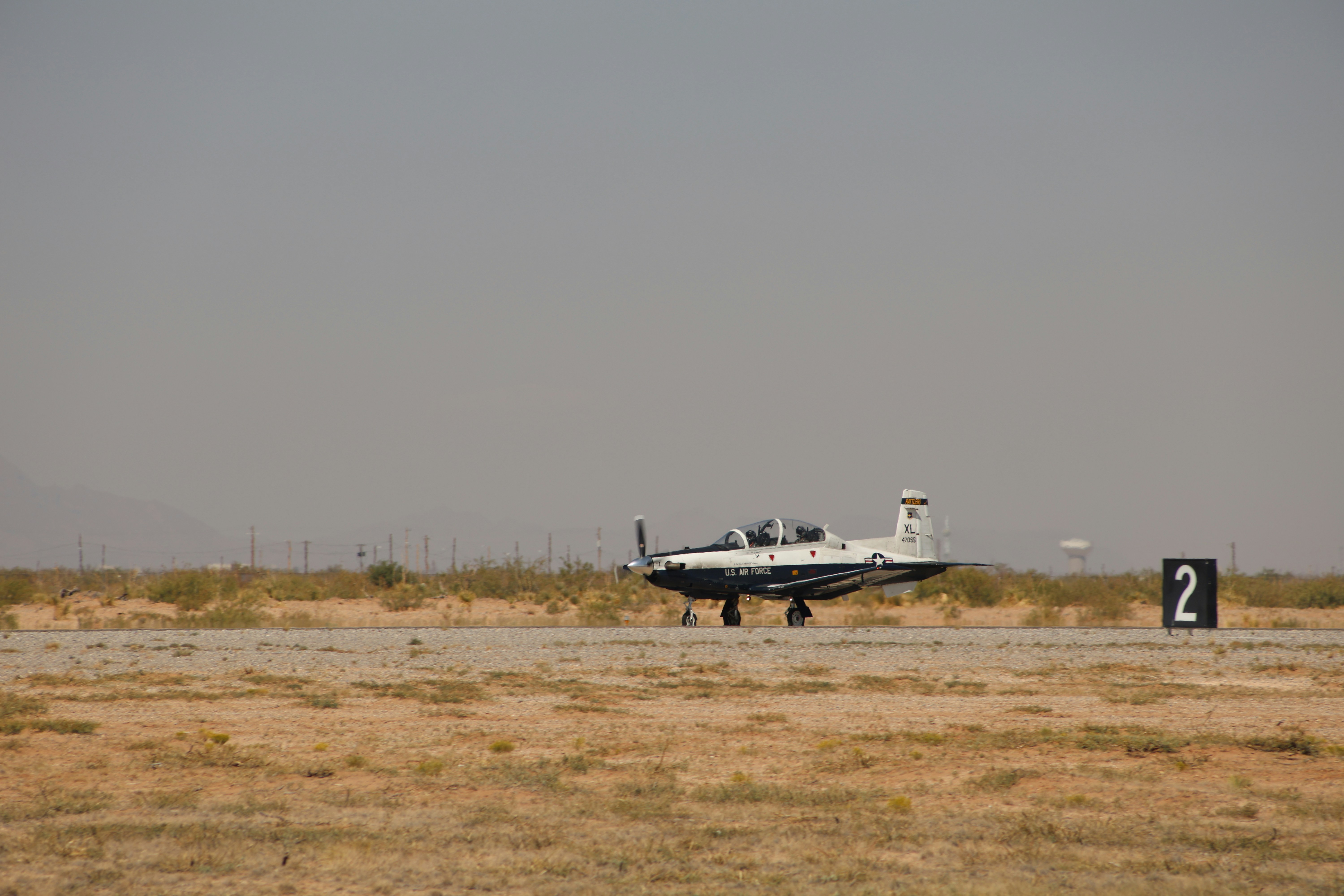 Desert Airstrip Dawn: A Silver Aircraft Resting on Parched Ground