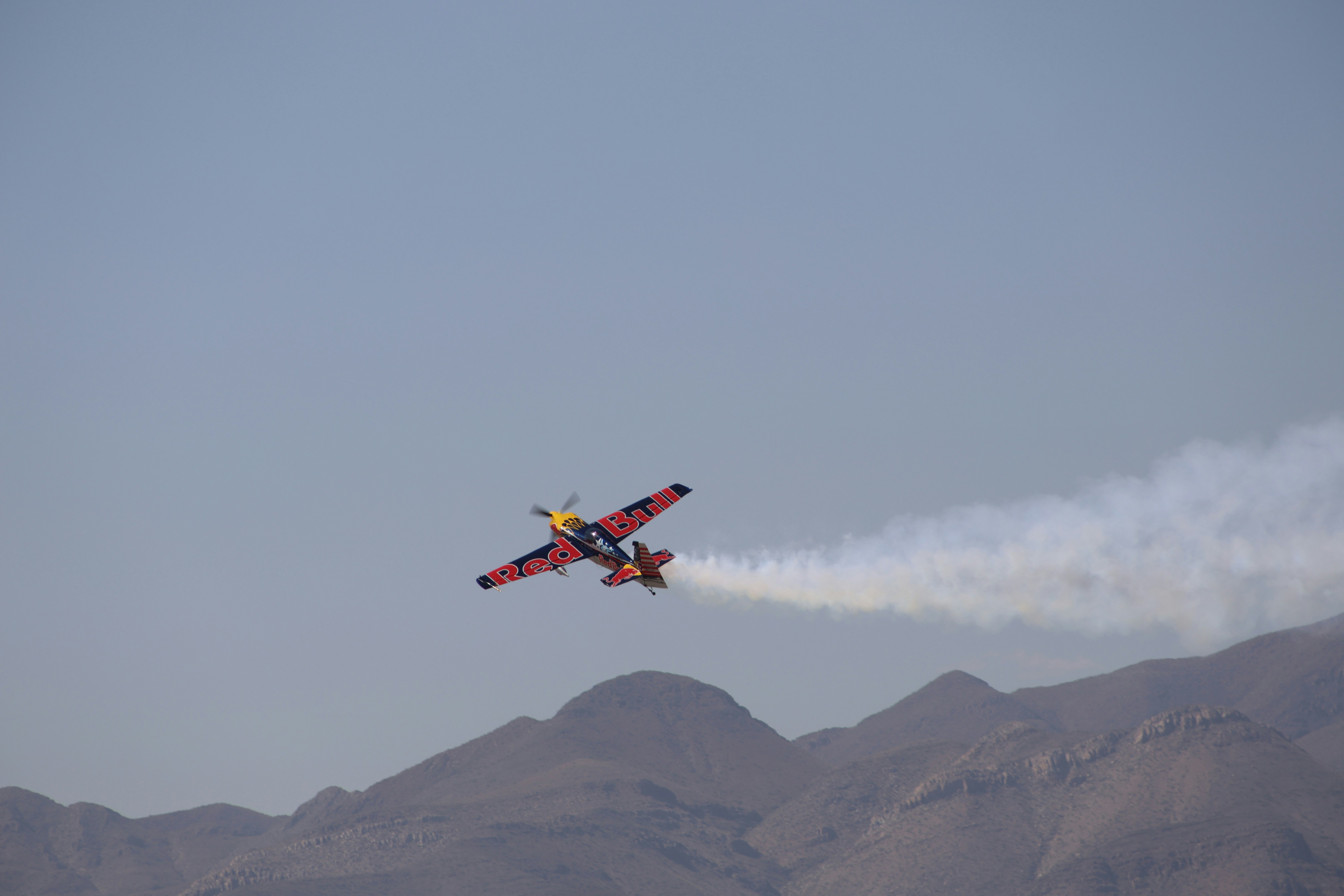 Red Bull Stunt Plane Over Desert Ridge