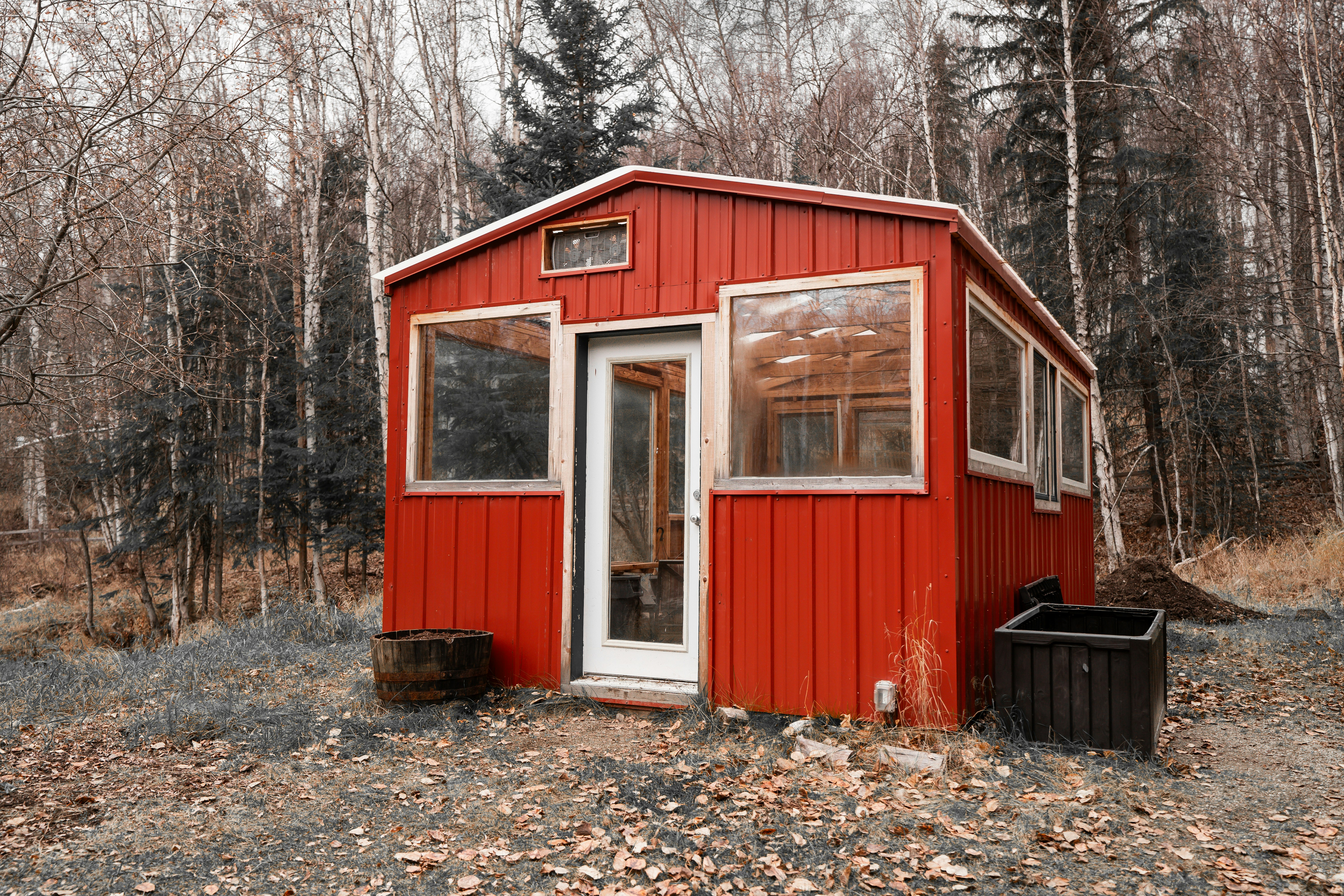 A small red building sitting in the middle of a forest photo – Free ...