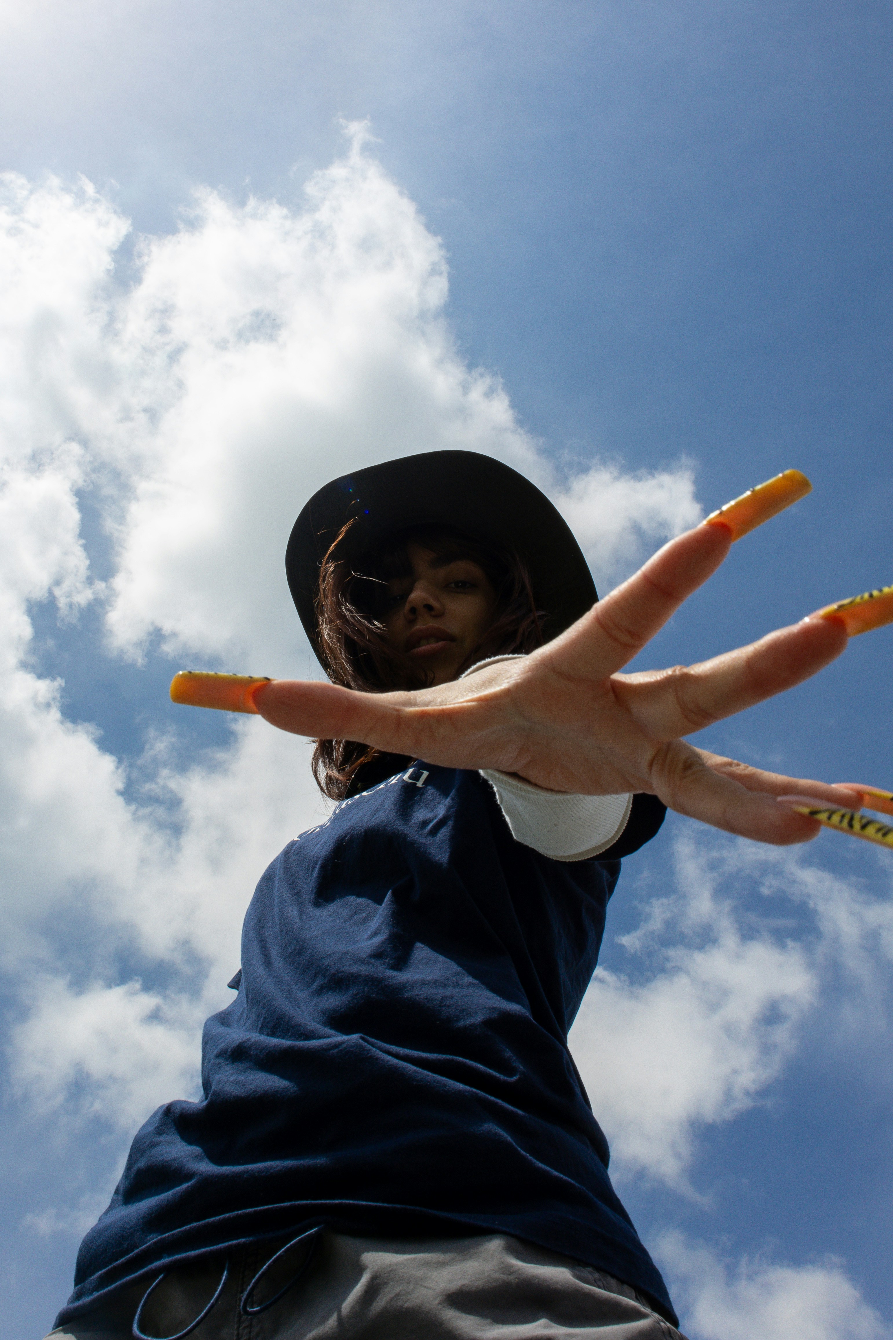 Face to the Sky: A Reaching Gesture Framed by Blue