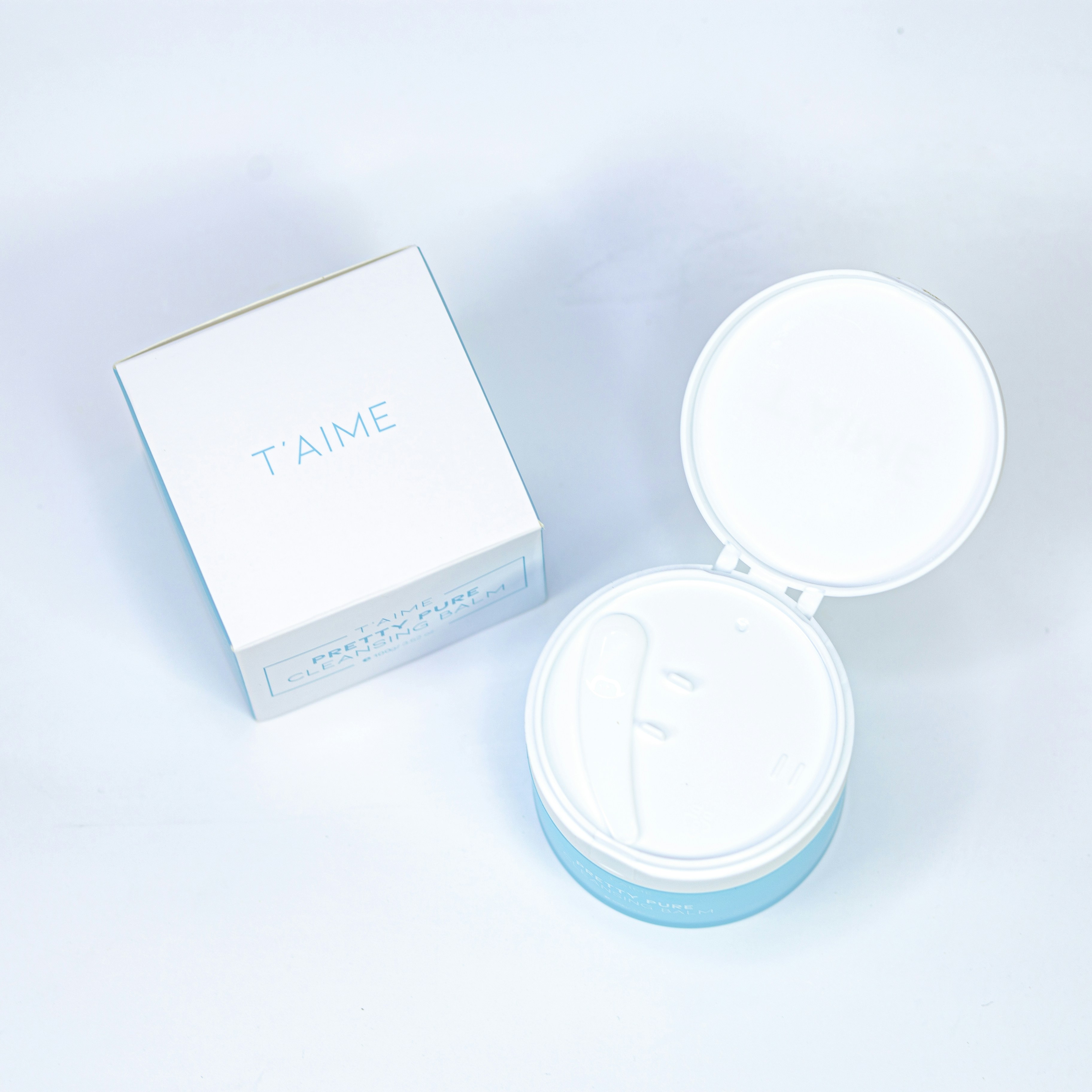 A white box with a blue lid and a white box with the word tame on photo ...