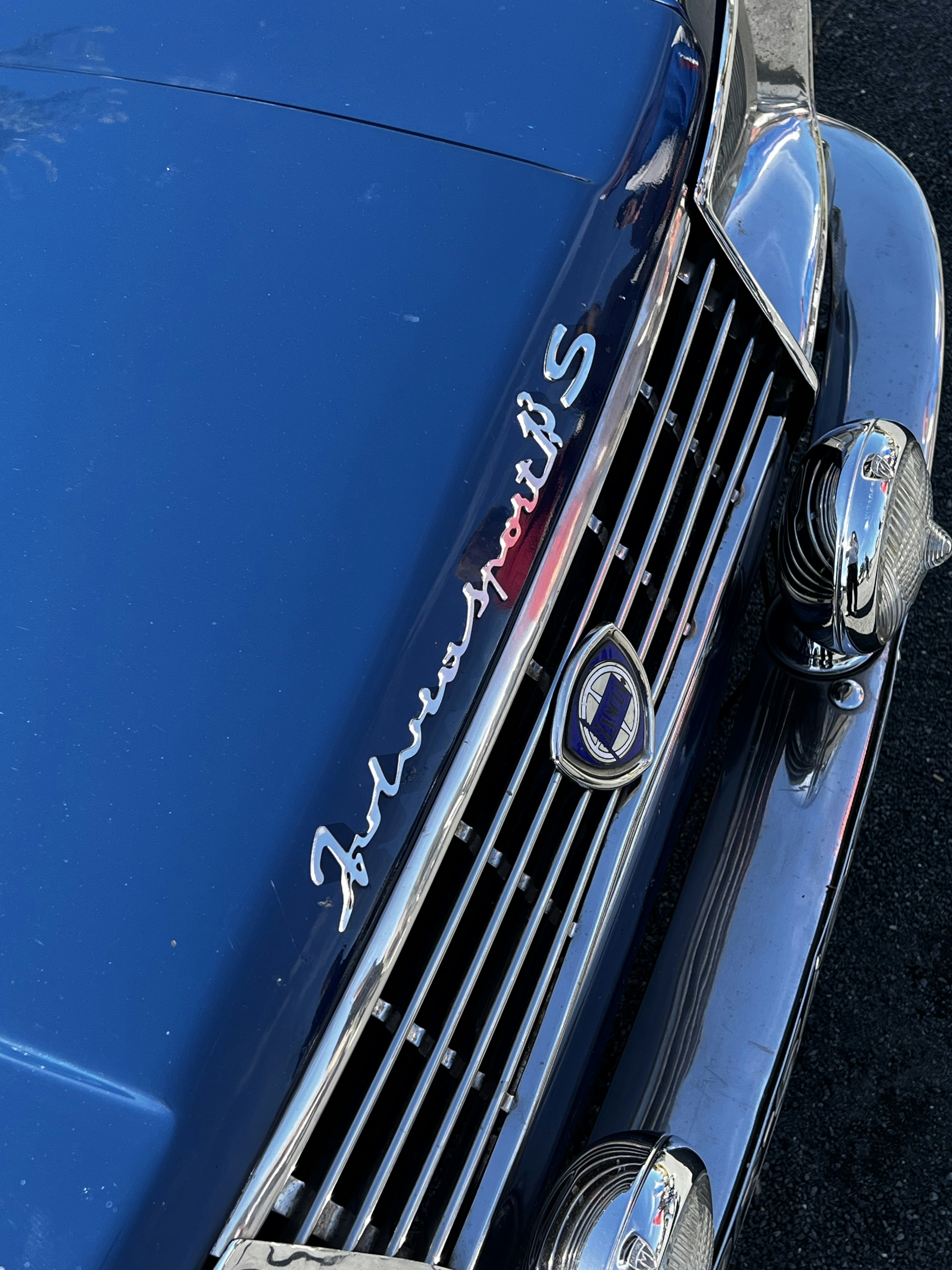 Azure Classic Hood: Close-up of chrome grille and crest on a vintage blue sedan