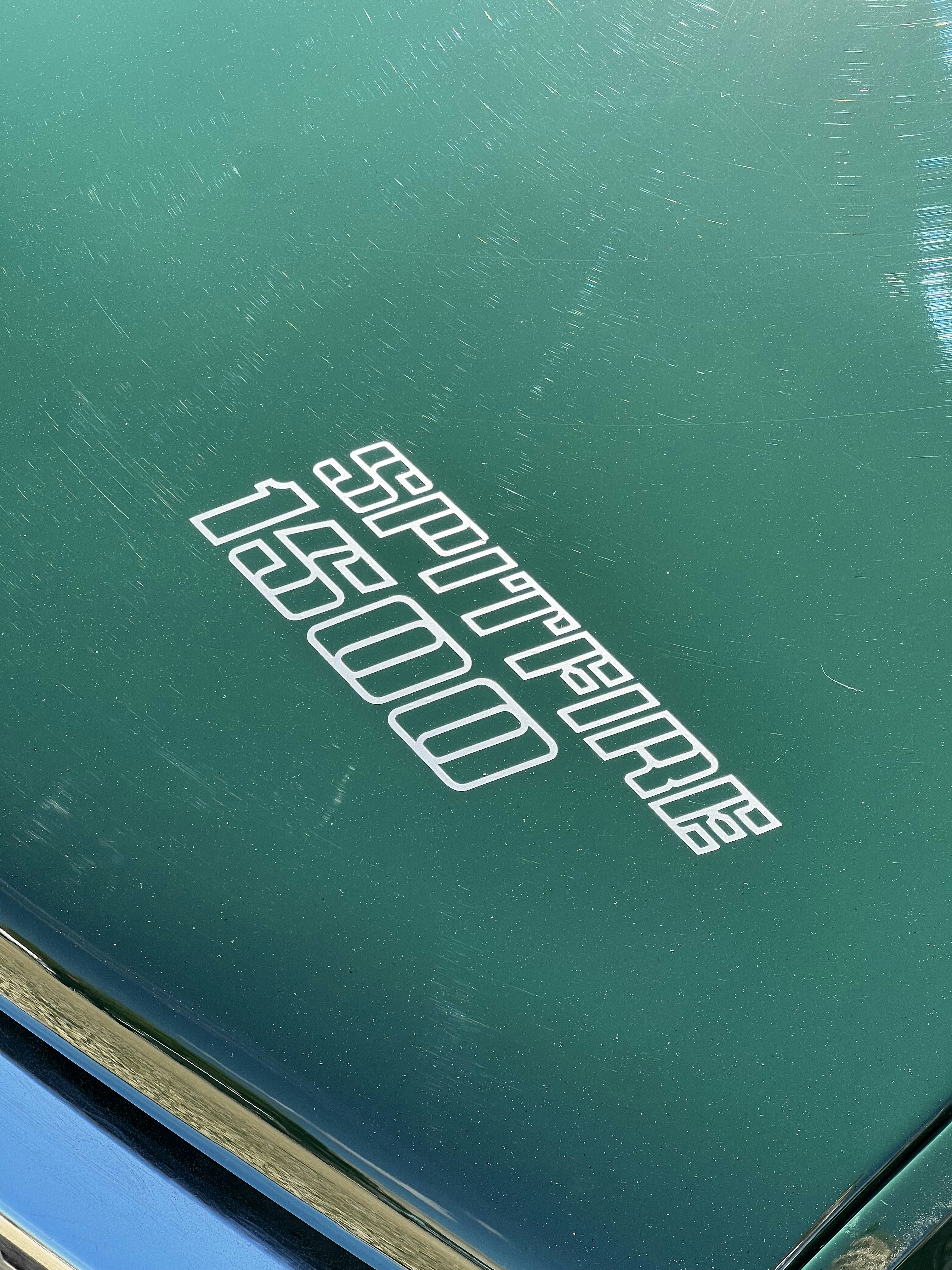 Diagonal White Geometric Logo on Teal Car Hood
