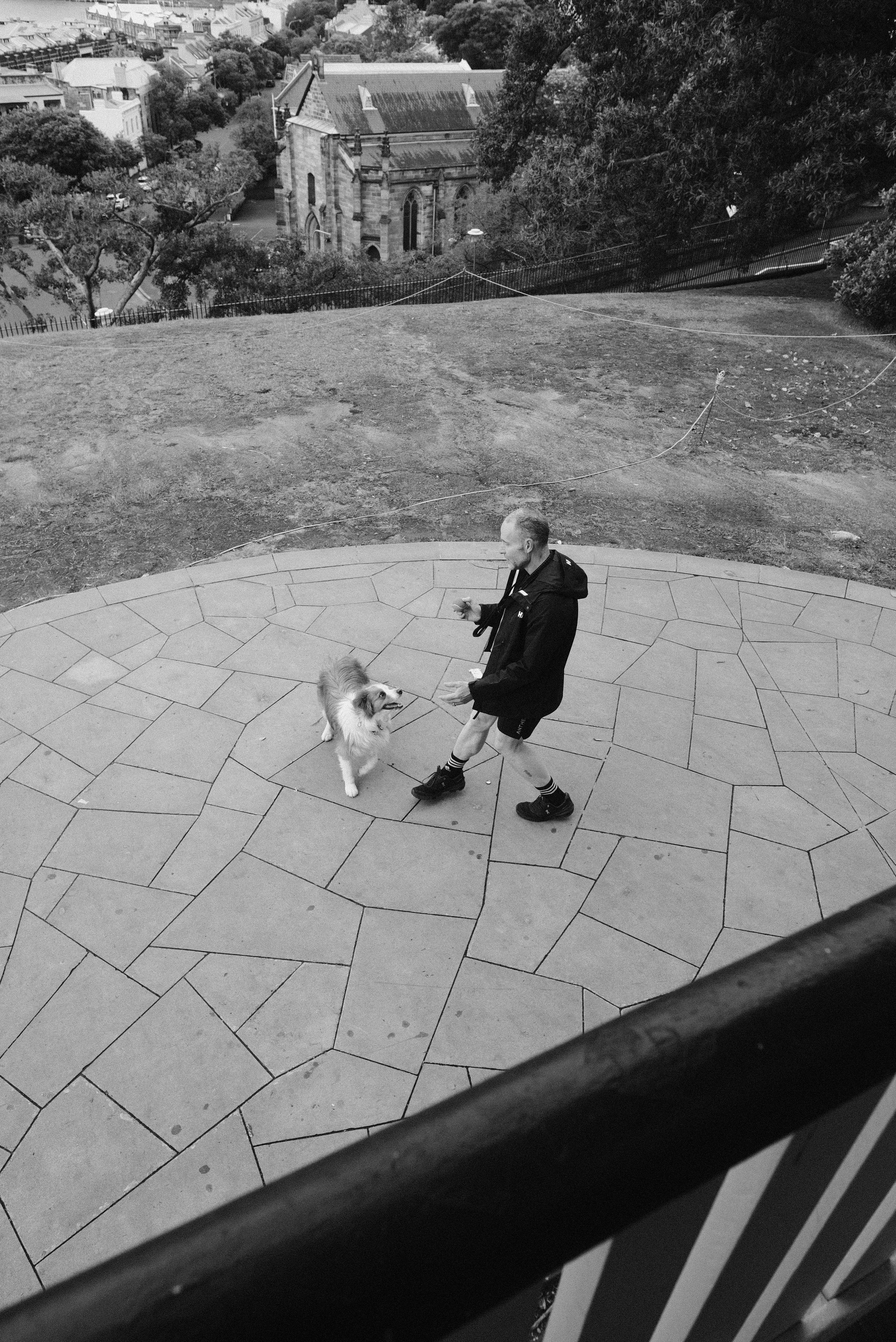 Circular Plaza Encounter: Man and Dog in Quiet Motion