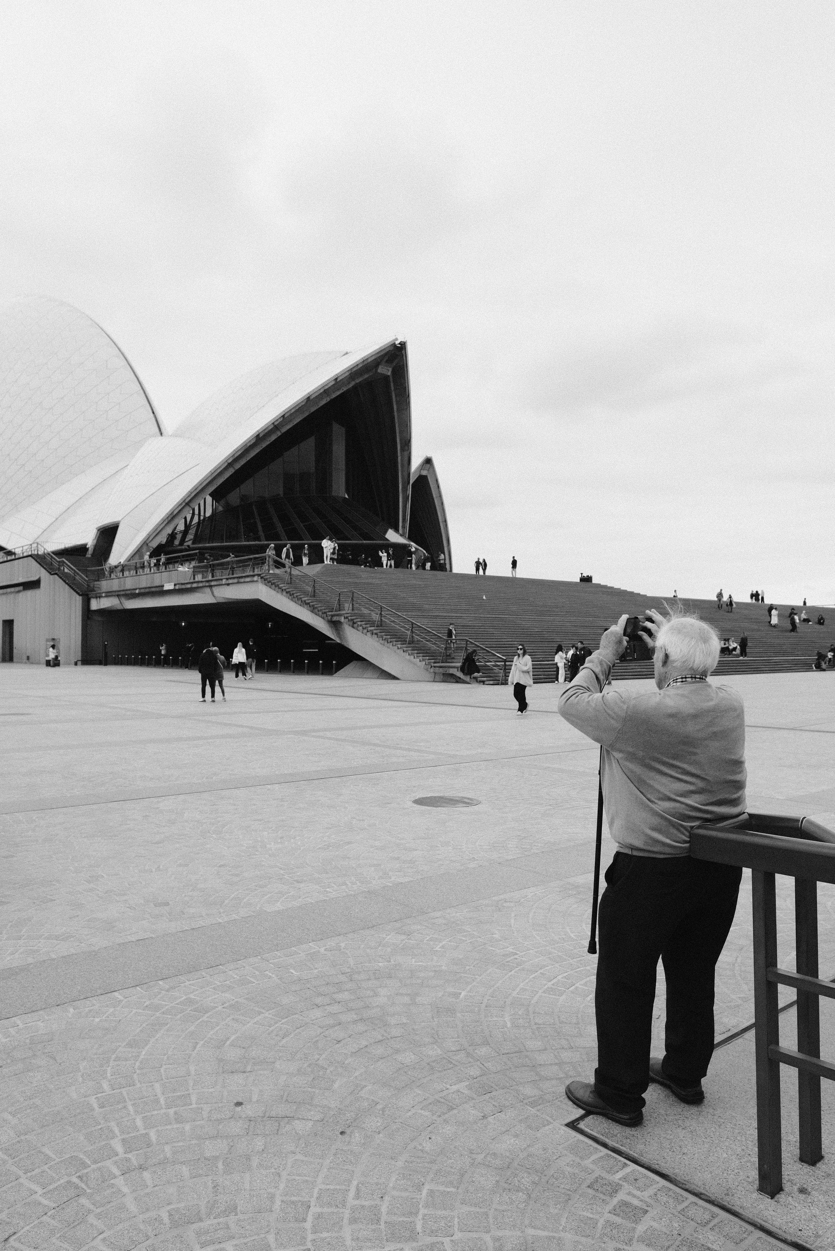 A black and white photo of a man taking a picture