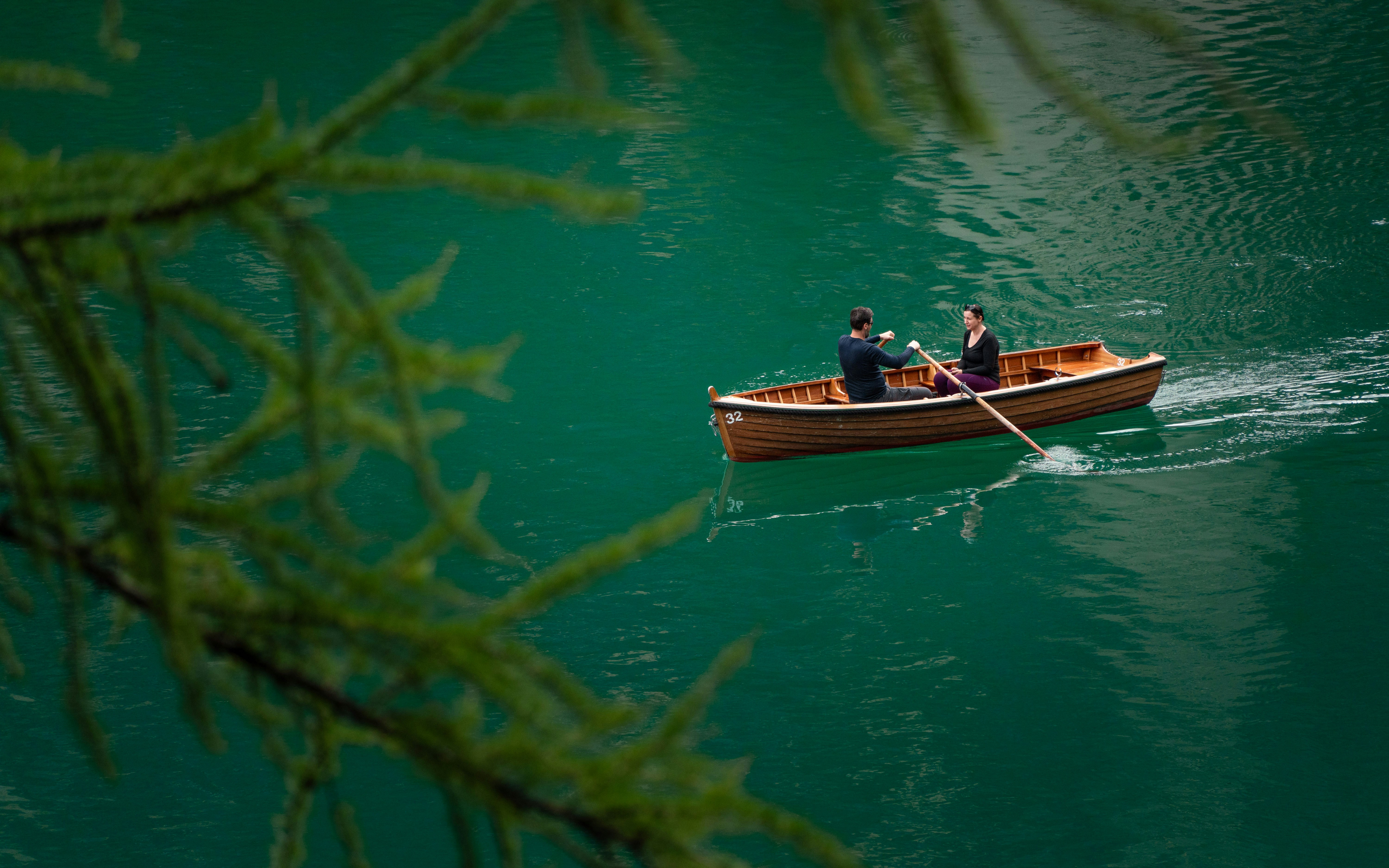 Two people in a small boat on a body of water photo – Free Human Image ...