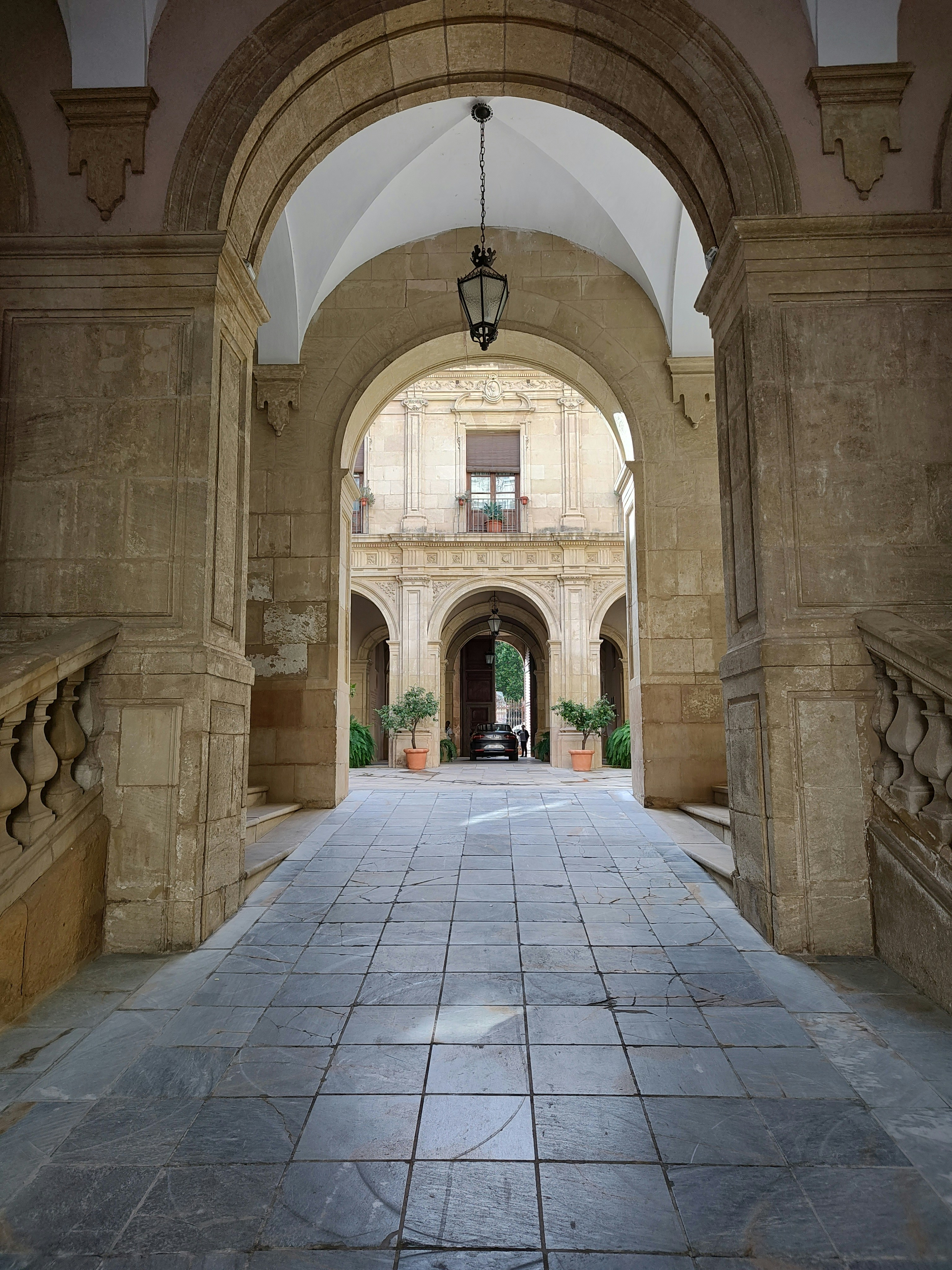 An archway leading into a building with a clock on the wall