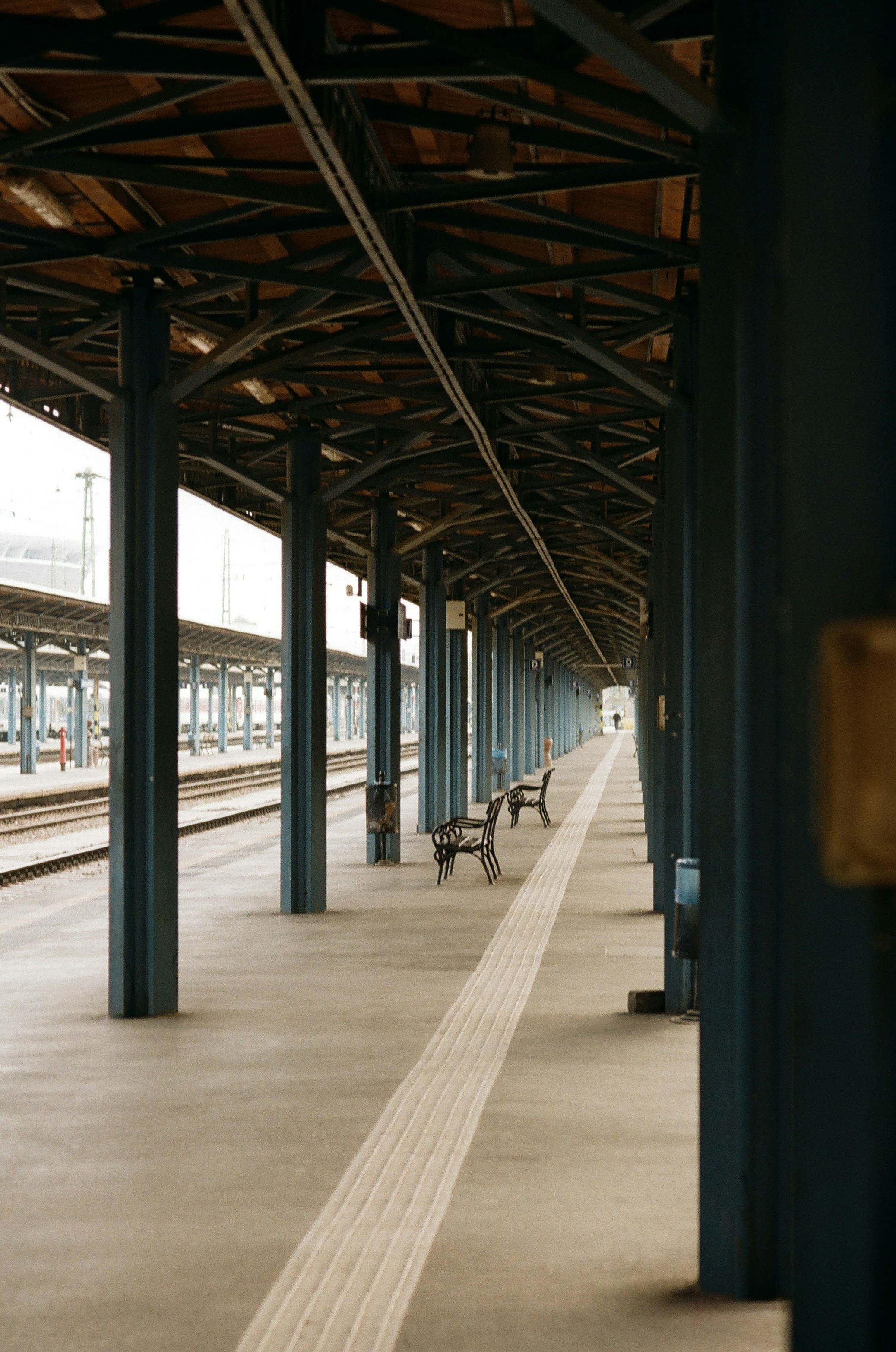 A train station with benches and a train on the tracks photo – Free ...