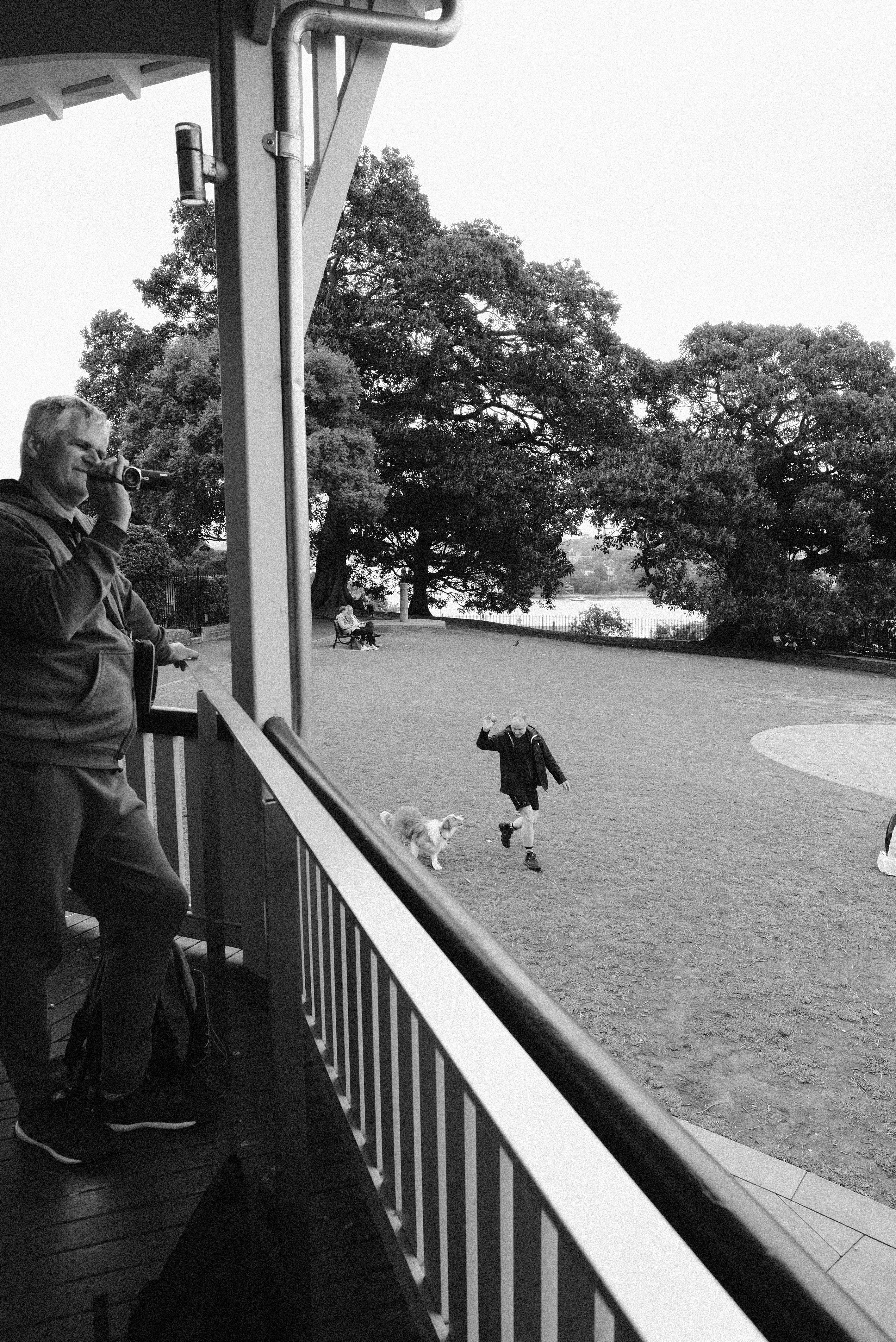Balcony Lens: A Quiet Moment of Observation Over a Riverside Park
