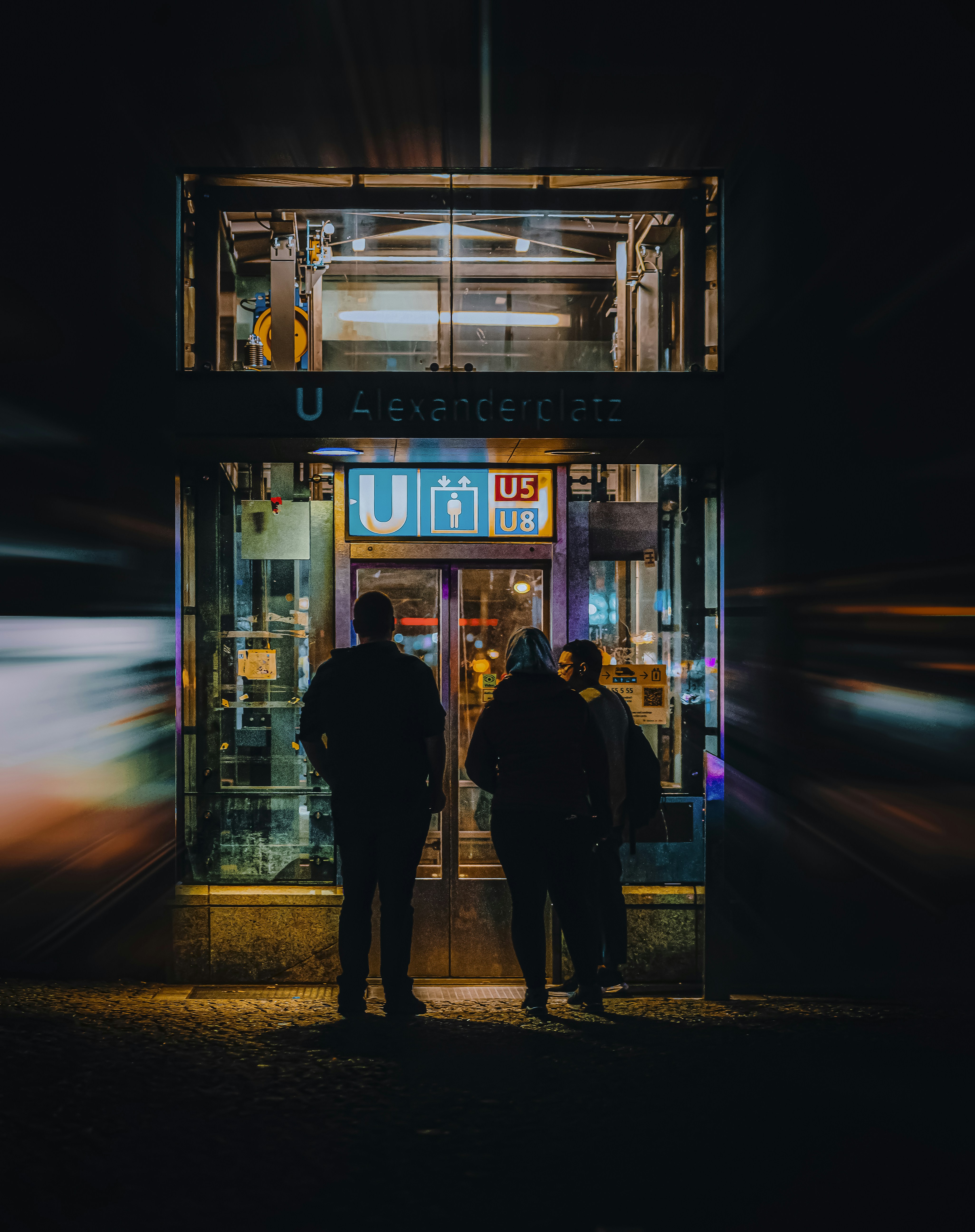 Midnight Convergence at U Alexanderplatz: silhouettes before glass metro doors