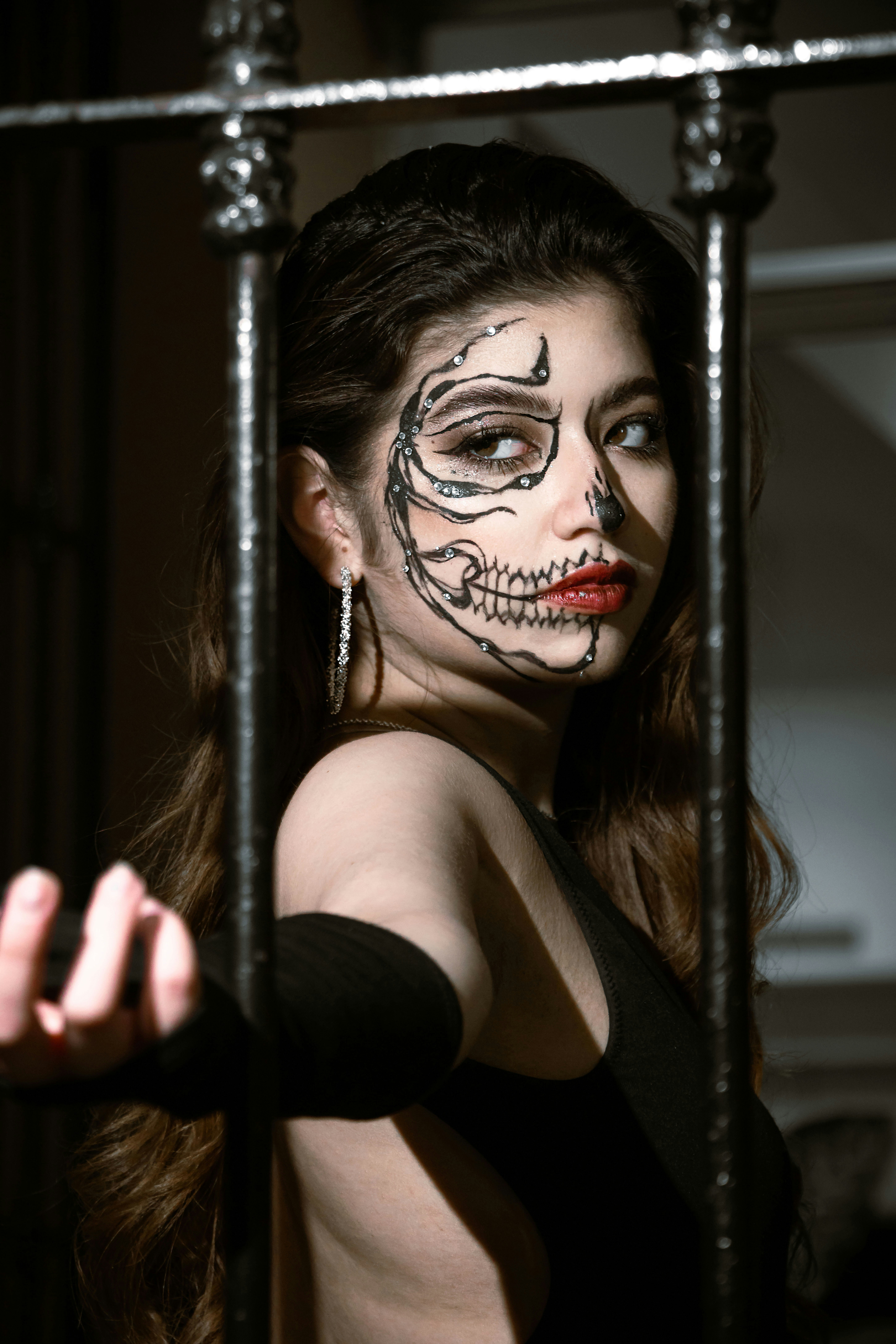 A woman with a skeleton painted on her face behind bars photo – Free ...