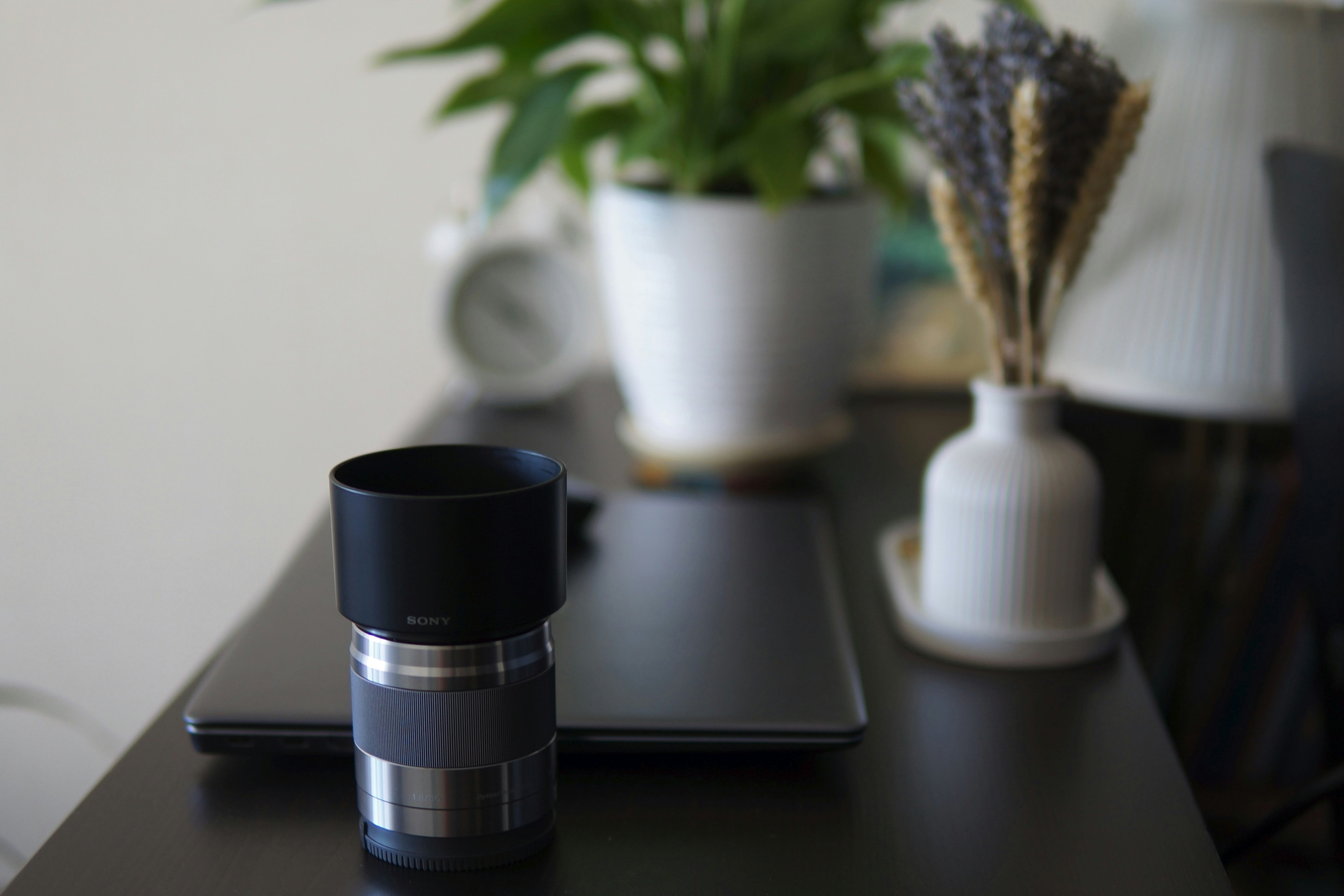 Desk-side Prime: A Stilled Lens Anchoring a Quiet Studio Moment
