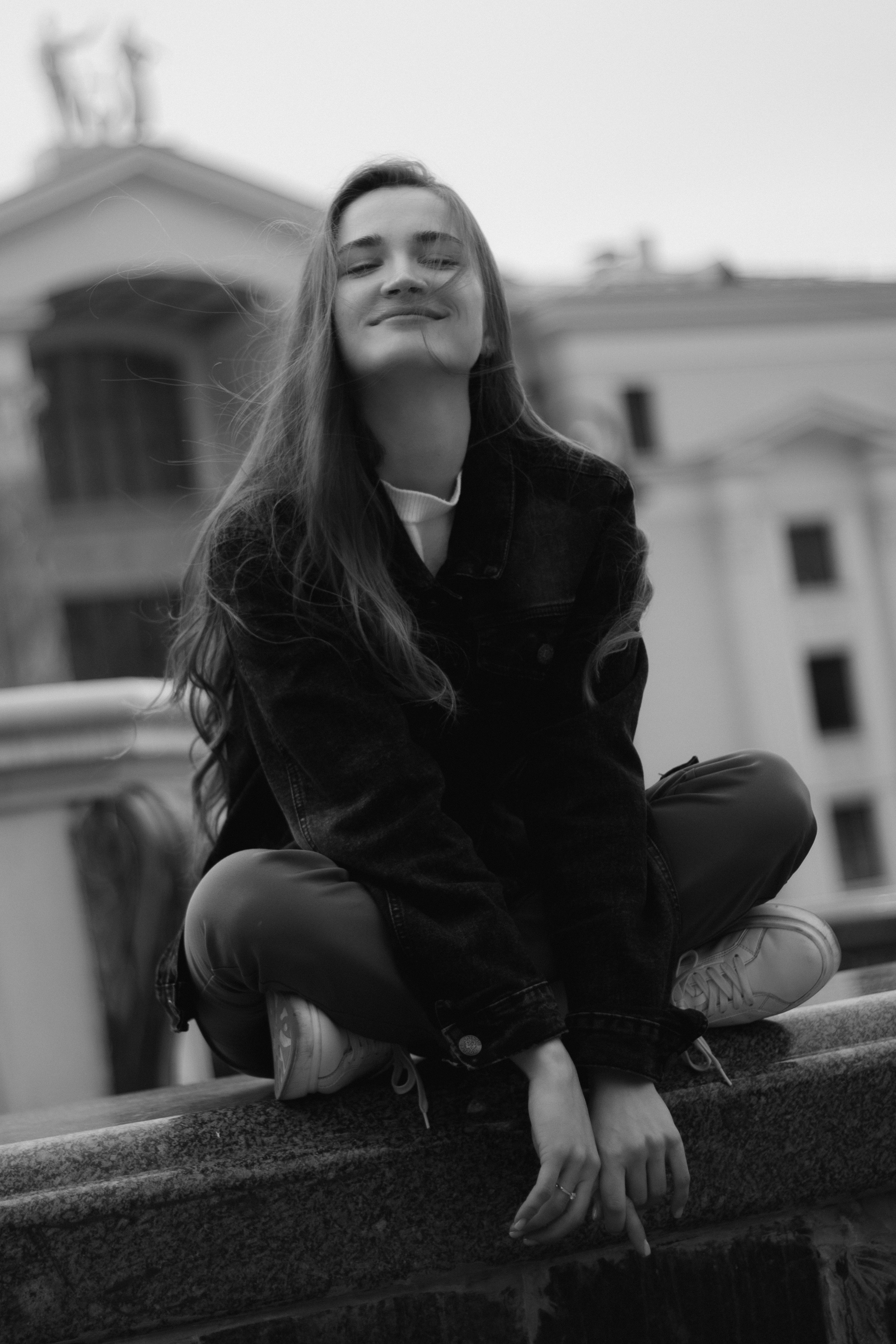 A woman sitting on a ledge with her eyes closed photo – Free Portrait ...