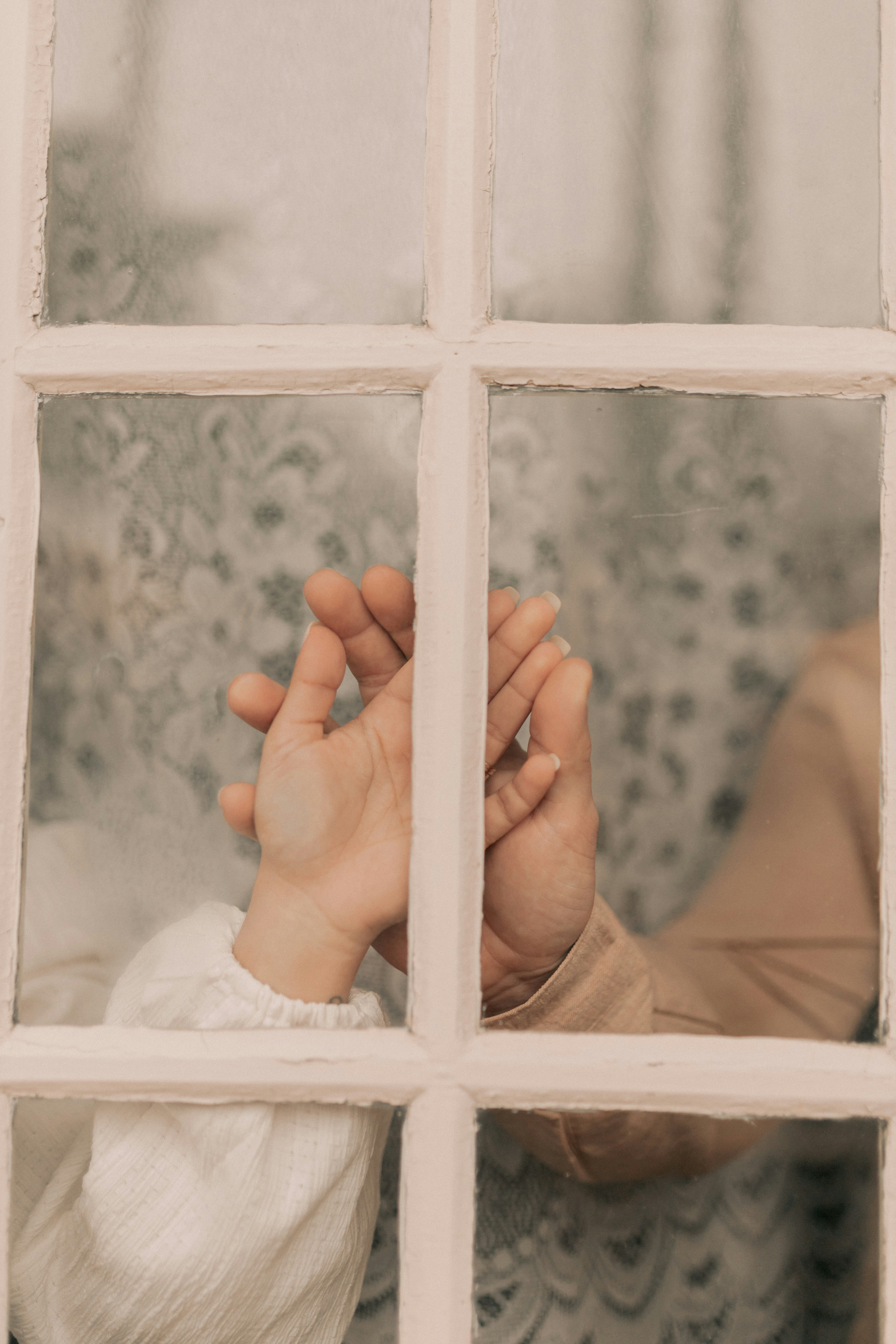 Cradled in Glass: Hands Behind Windowpanes